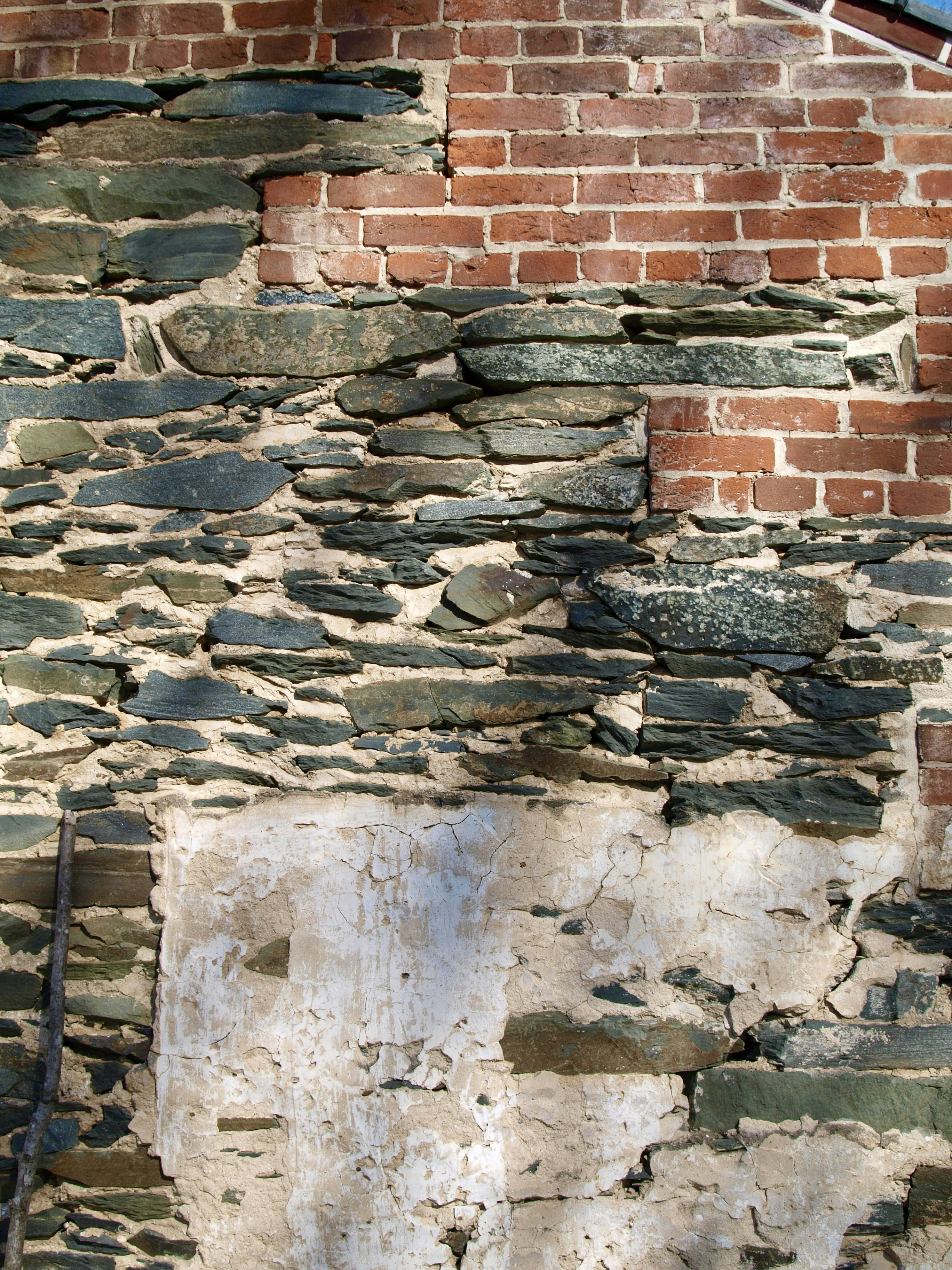 Patchwork Chronicle: Slate, Plaster, and Brick on a Weathered Facade