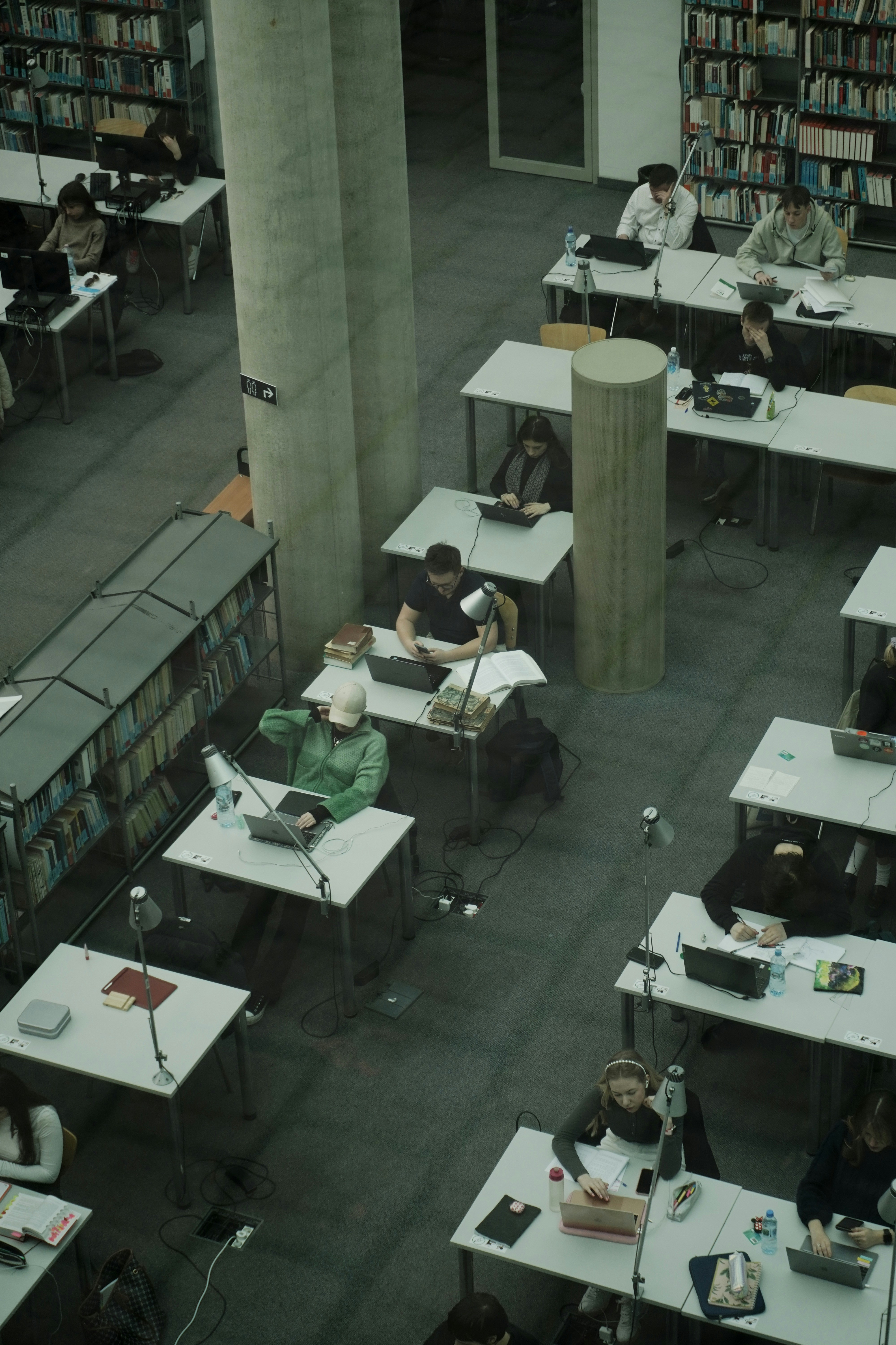 A group of people sitting at desks in a library photo – Free Library ...