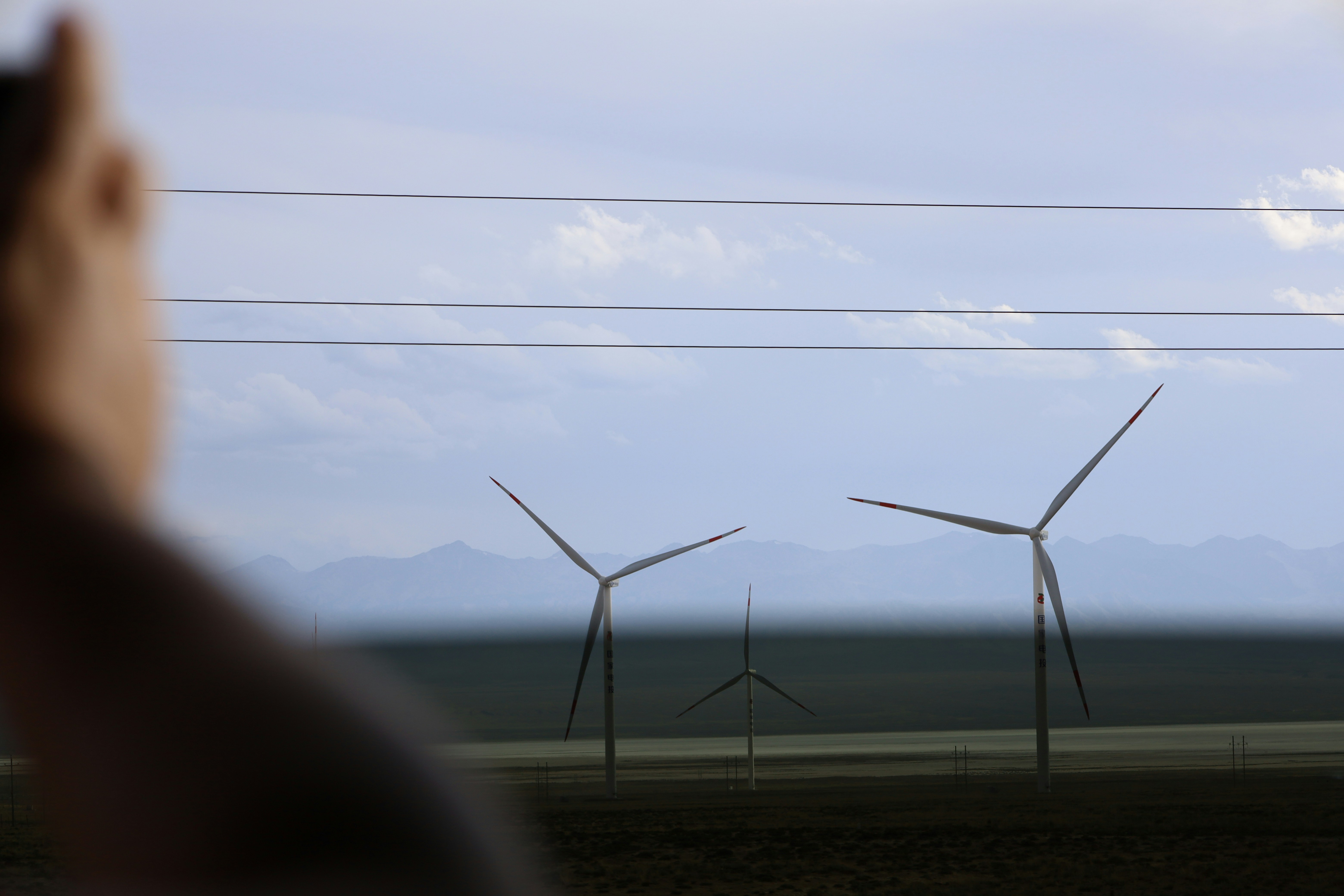 A person taking a picture of wind turbines photo – Free Qinghai Image ...