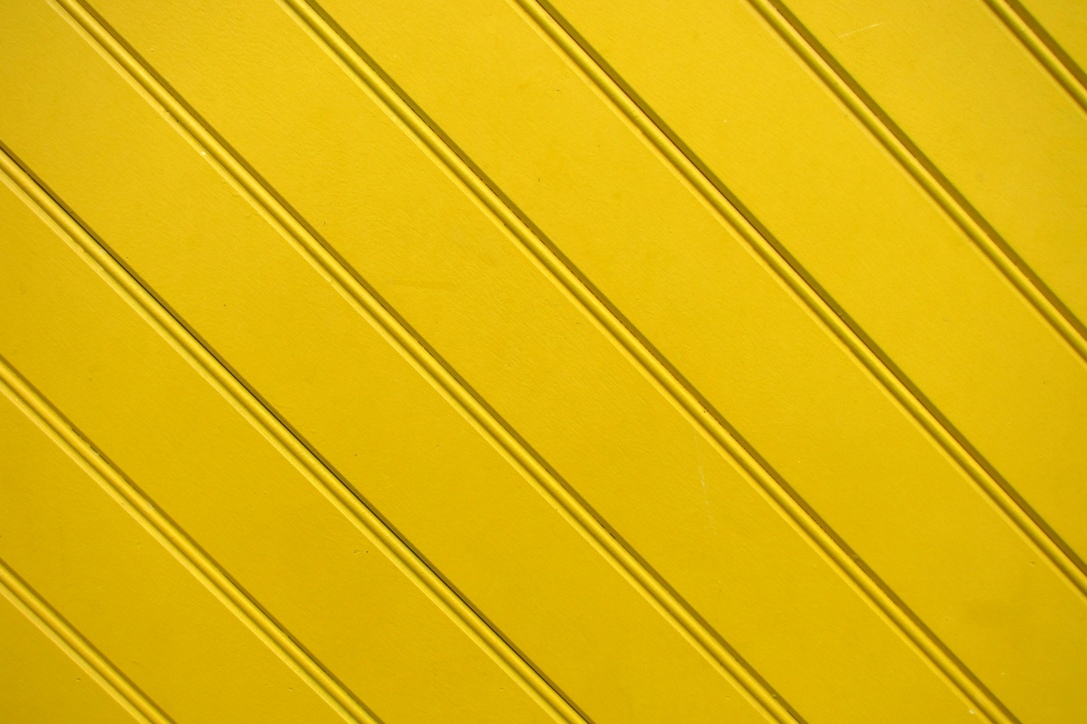 A yellow wall with vertical lines painted on it photo – Free Paralell ...