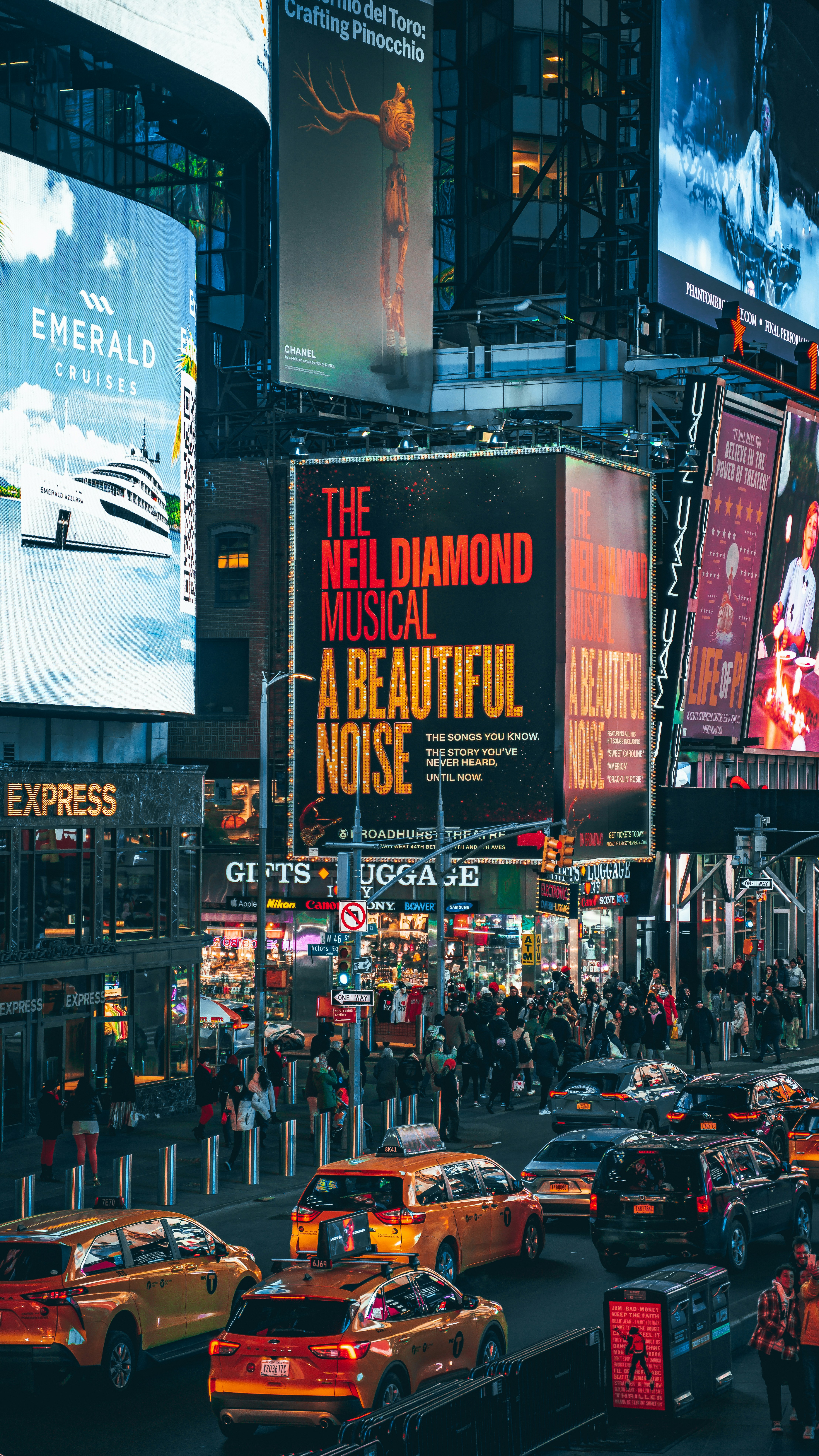 Neon Mosaic Over Times Square: The Neil Diamond Billboard Amid a River of Taxis