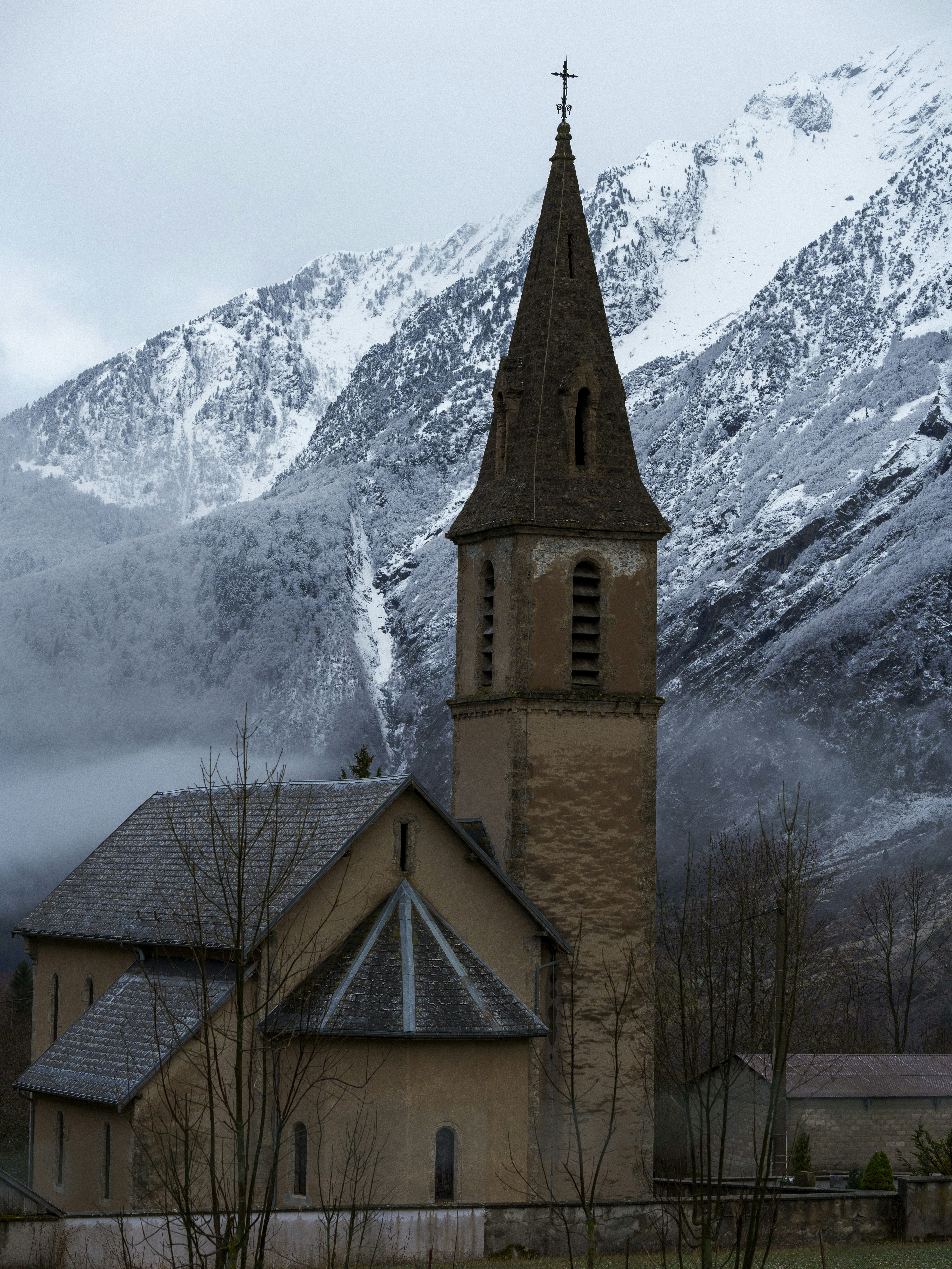 Steeple in the Snow: Alpine Church Rising Against Snow-Capped Peaks