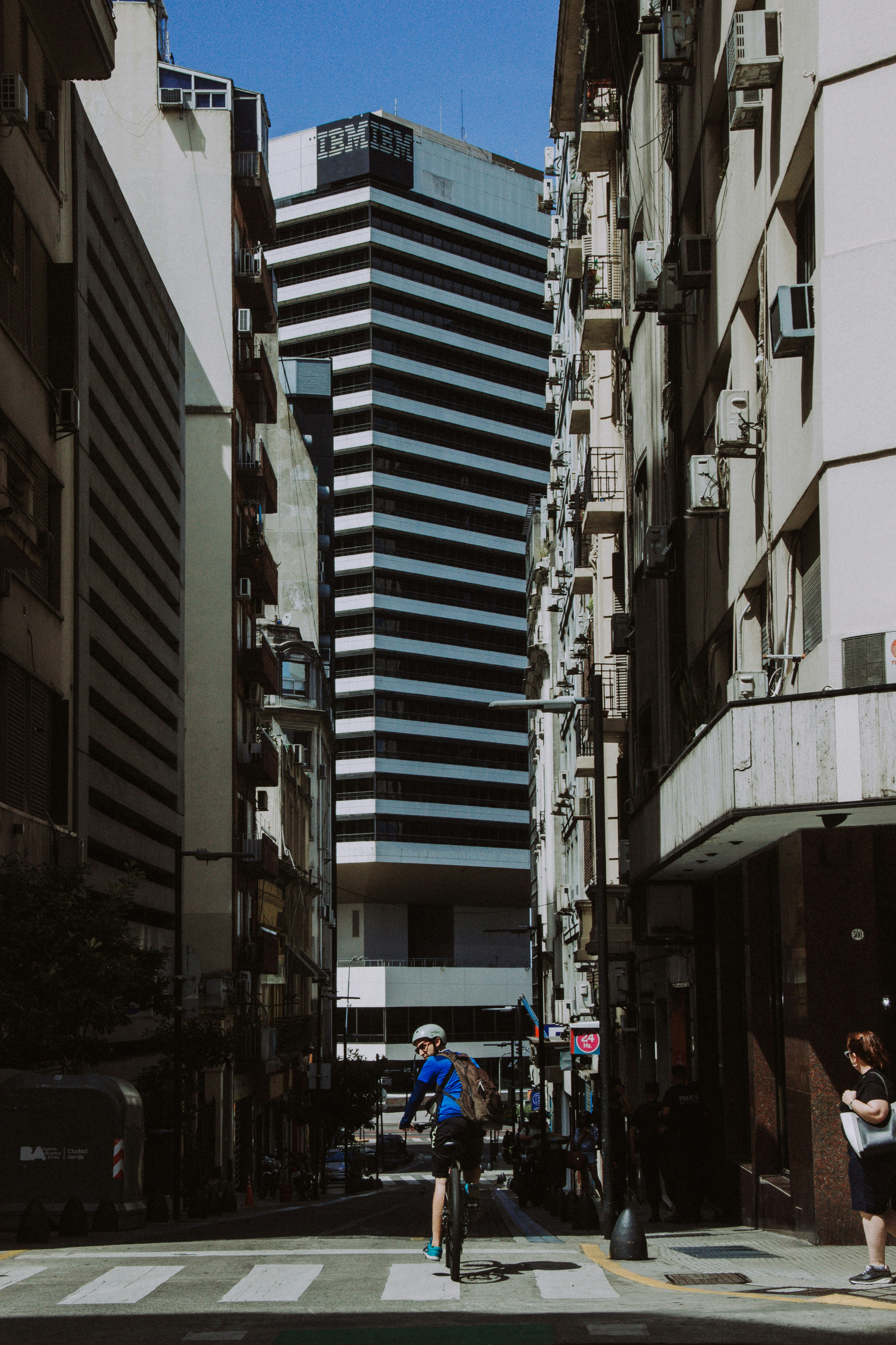 Blue Rider in a Concrete Canyon Toward a Striped Glass Tower