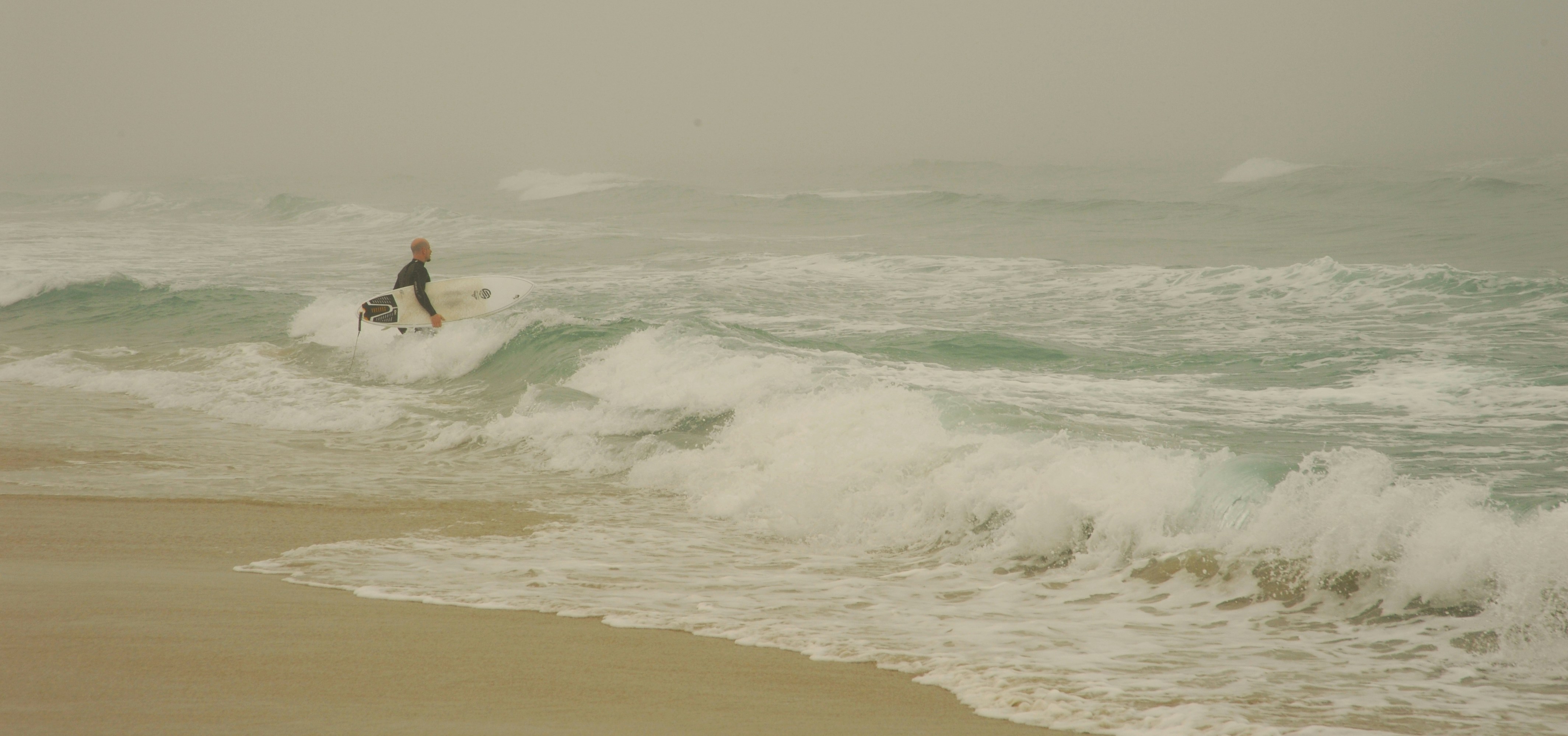 Surferalcrest at Dusk: A Lone Rider in Gentle Atlantic Breaks