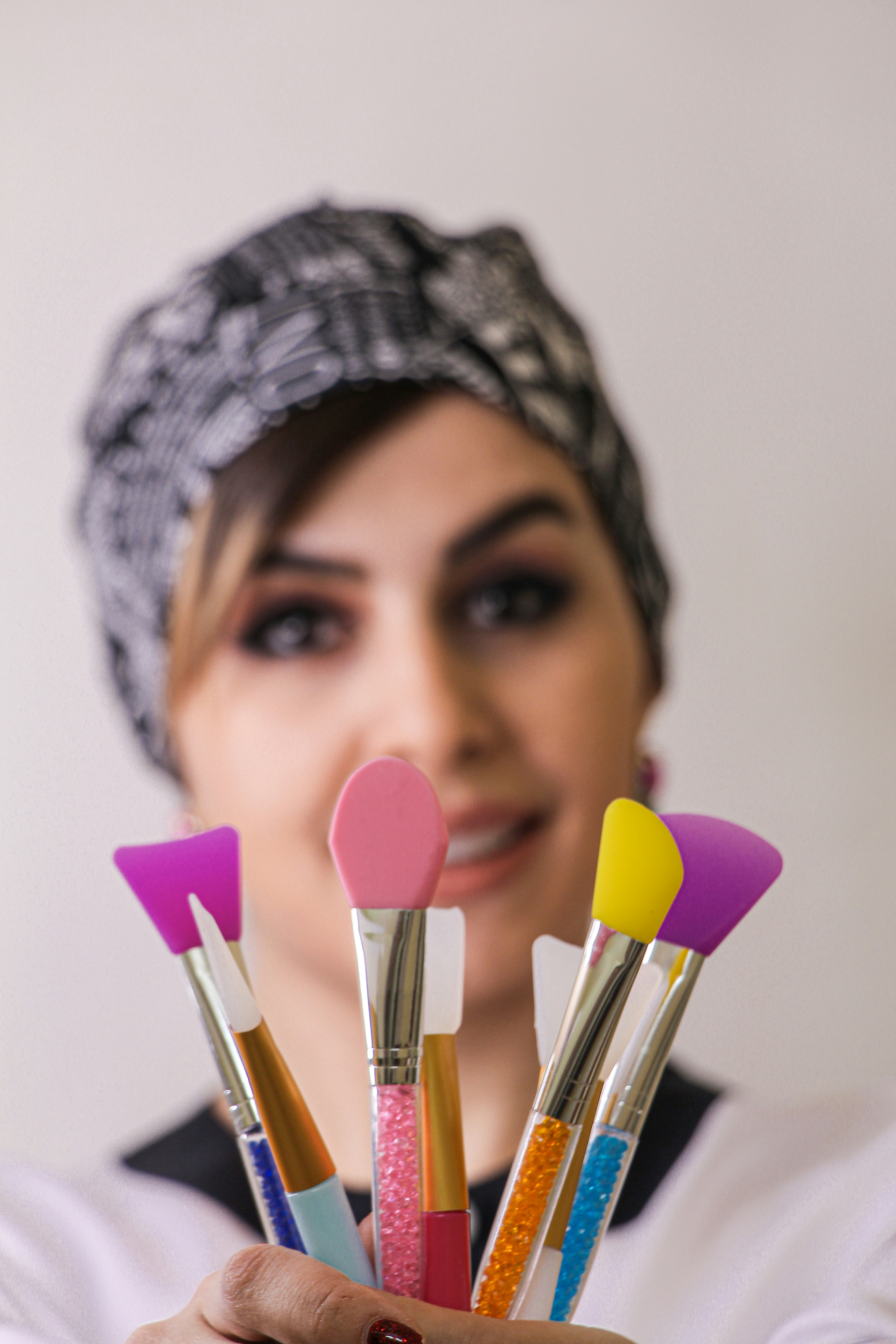 Foreground Palette: Vibrant Makeup Brushes Steal the Spotlight in a Soft Portrait