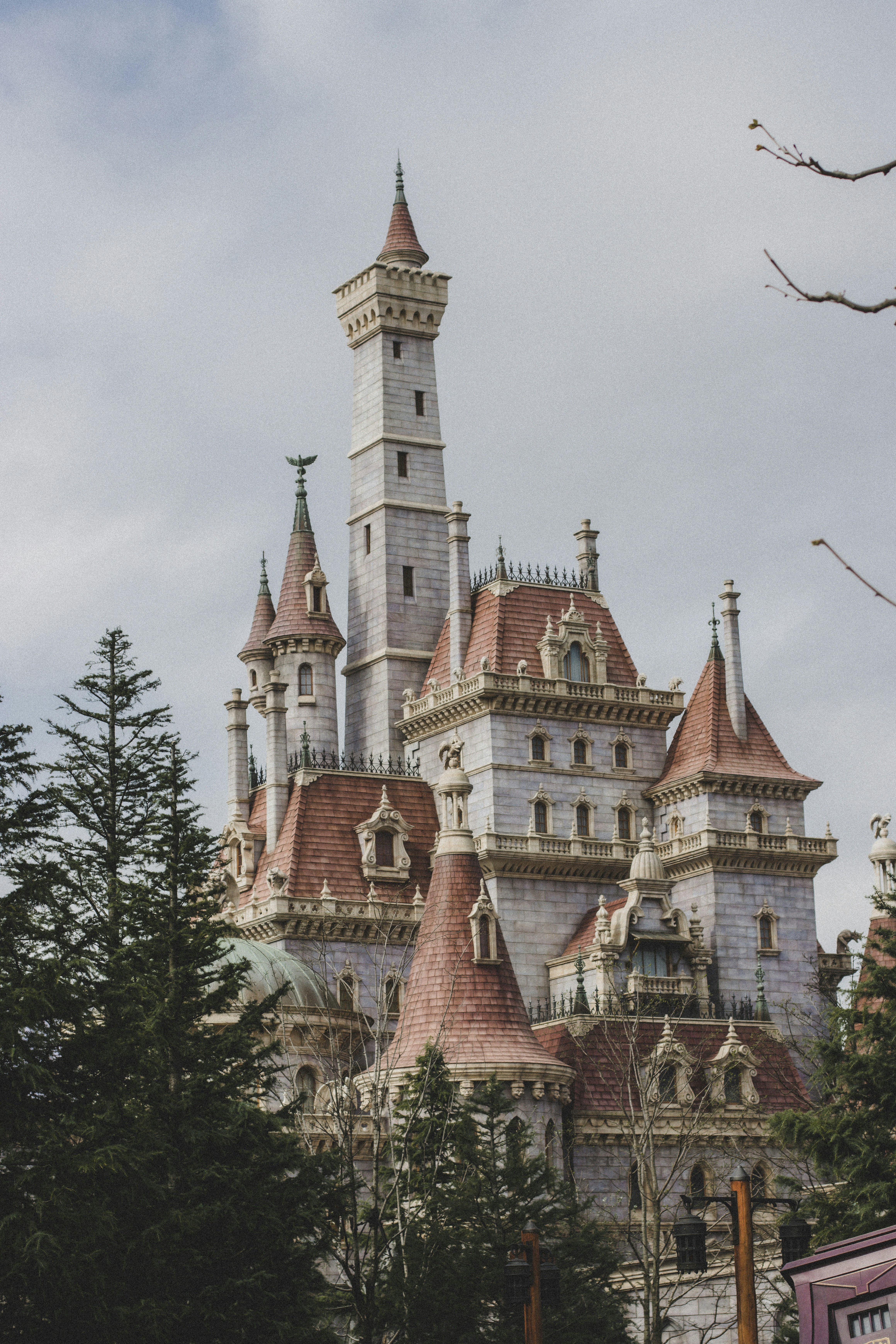 Crimson Spires Rise: A Fairy-Tale Castle Among Evergreen Pines