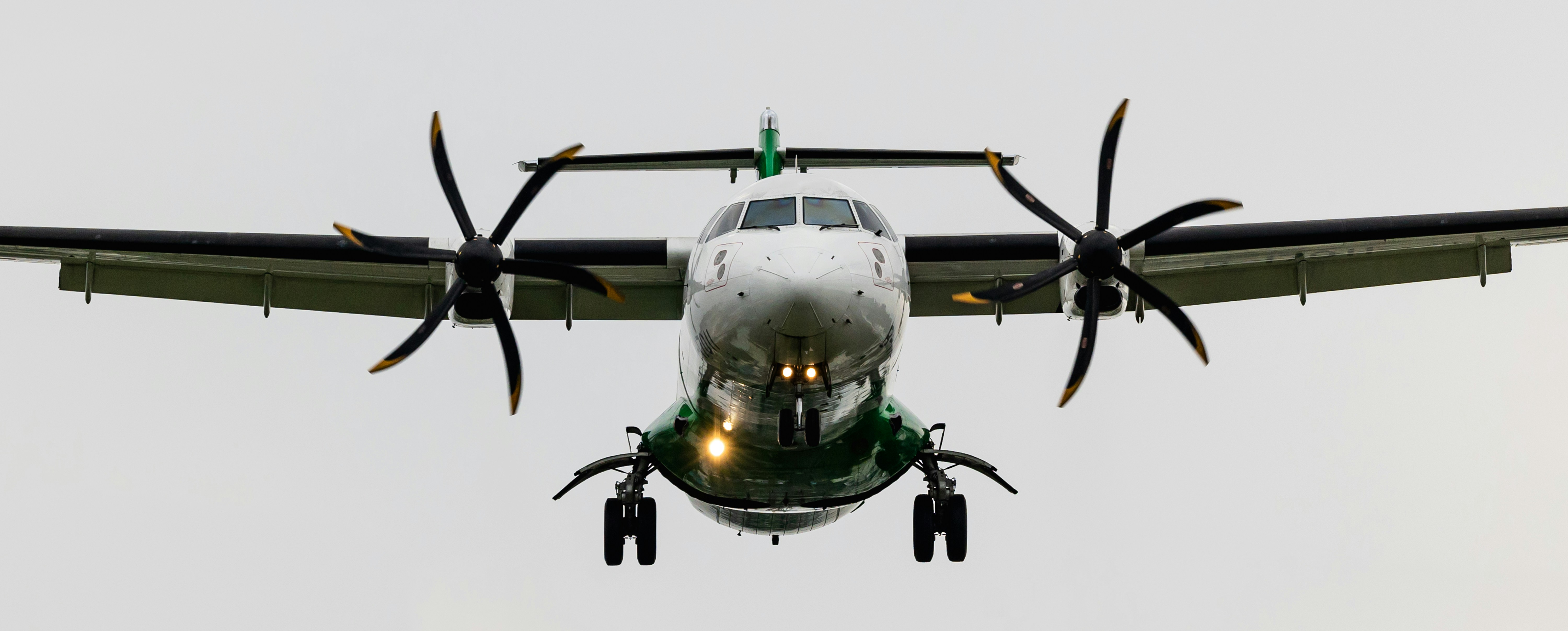 A large propeller plane flying through a gray sky photo – Free Aircraft ...