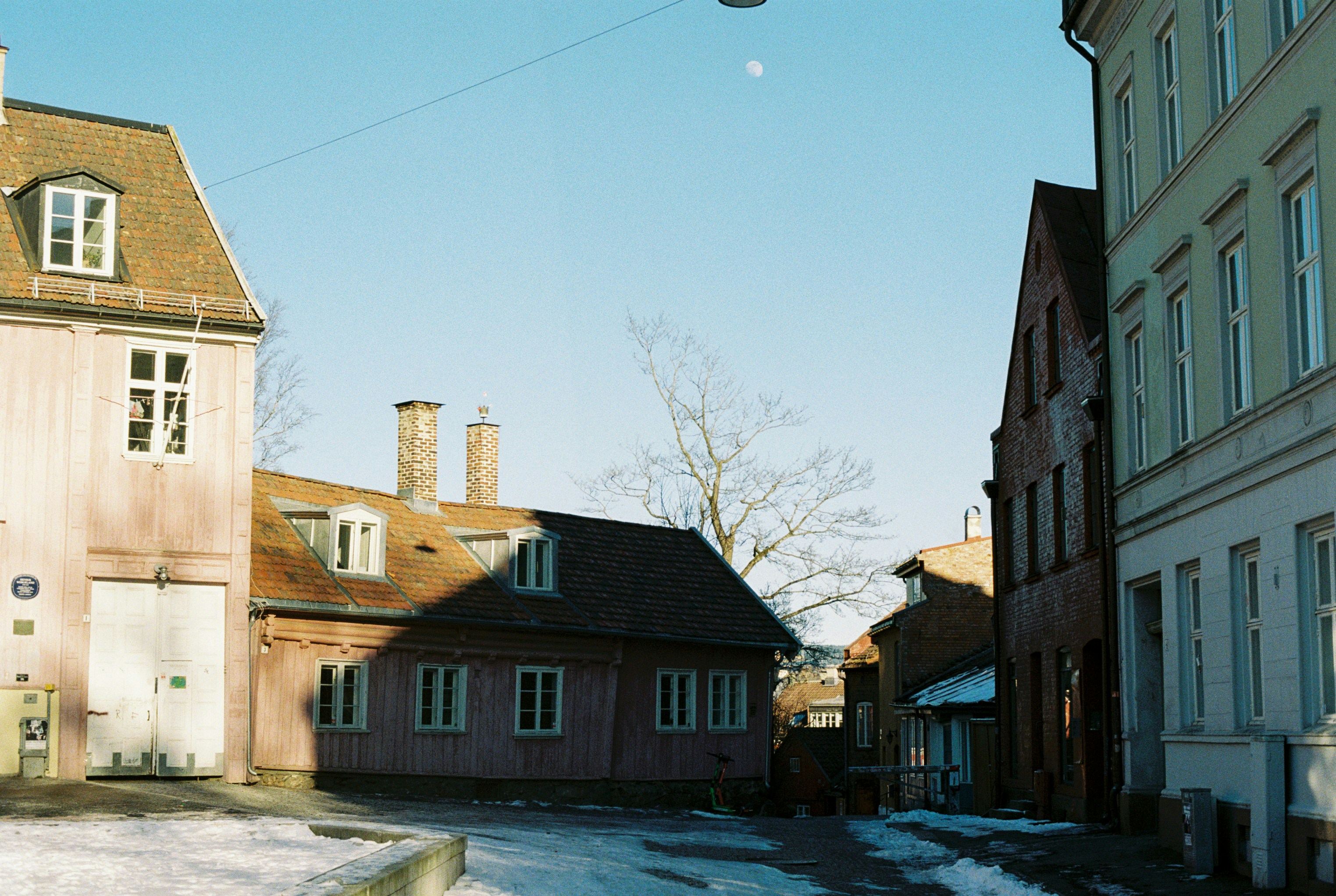 Winter Light Along a Quiet Town Street: Pink Facades and a Clear Blue Sky