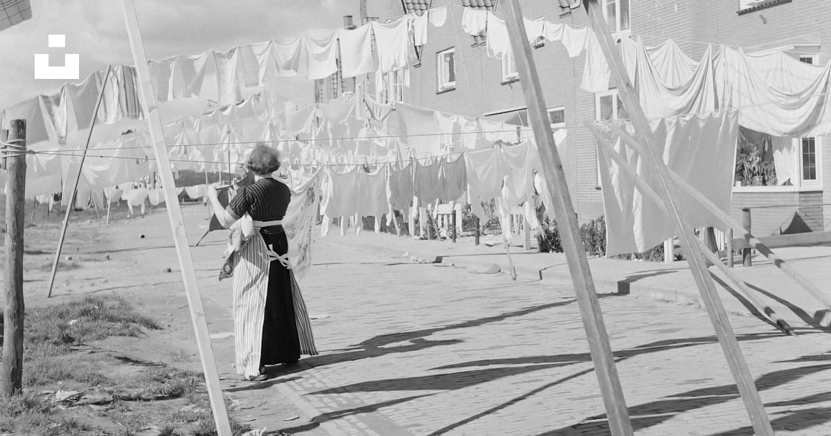 Una Foto En Blanco Y Negro De Una Mujer Parada Frente A Una Fila De