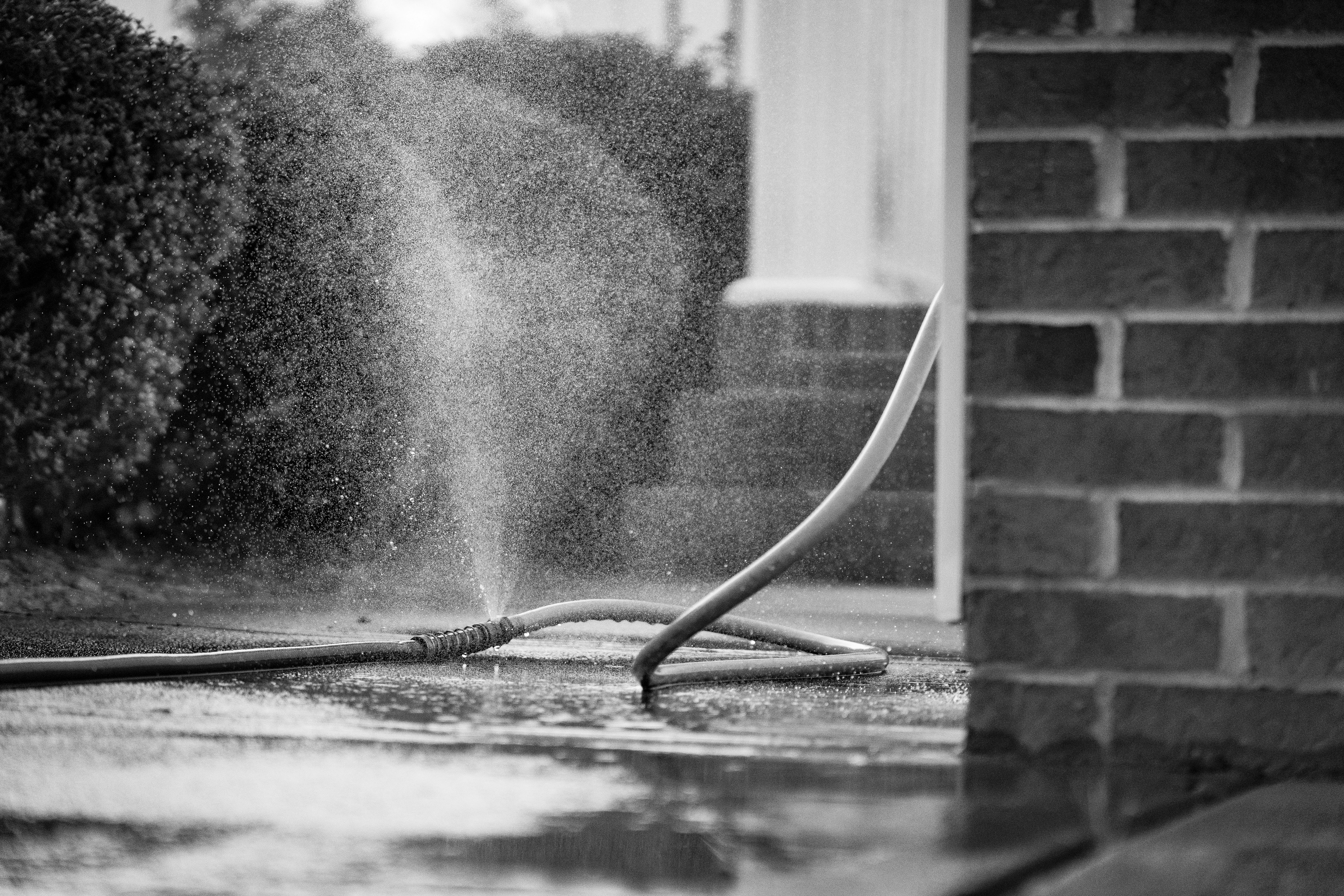 A fire hydrant spewing water onto a sidewalk photo – Free Rain Image on ...