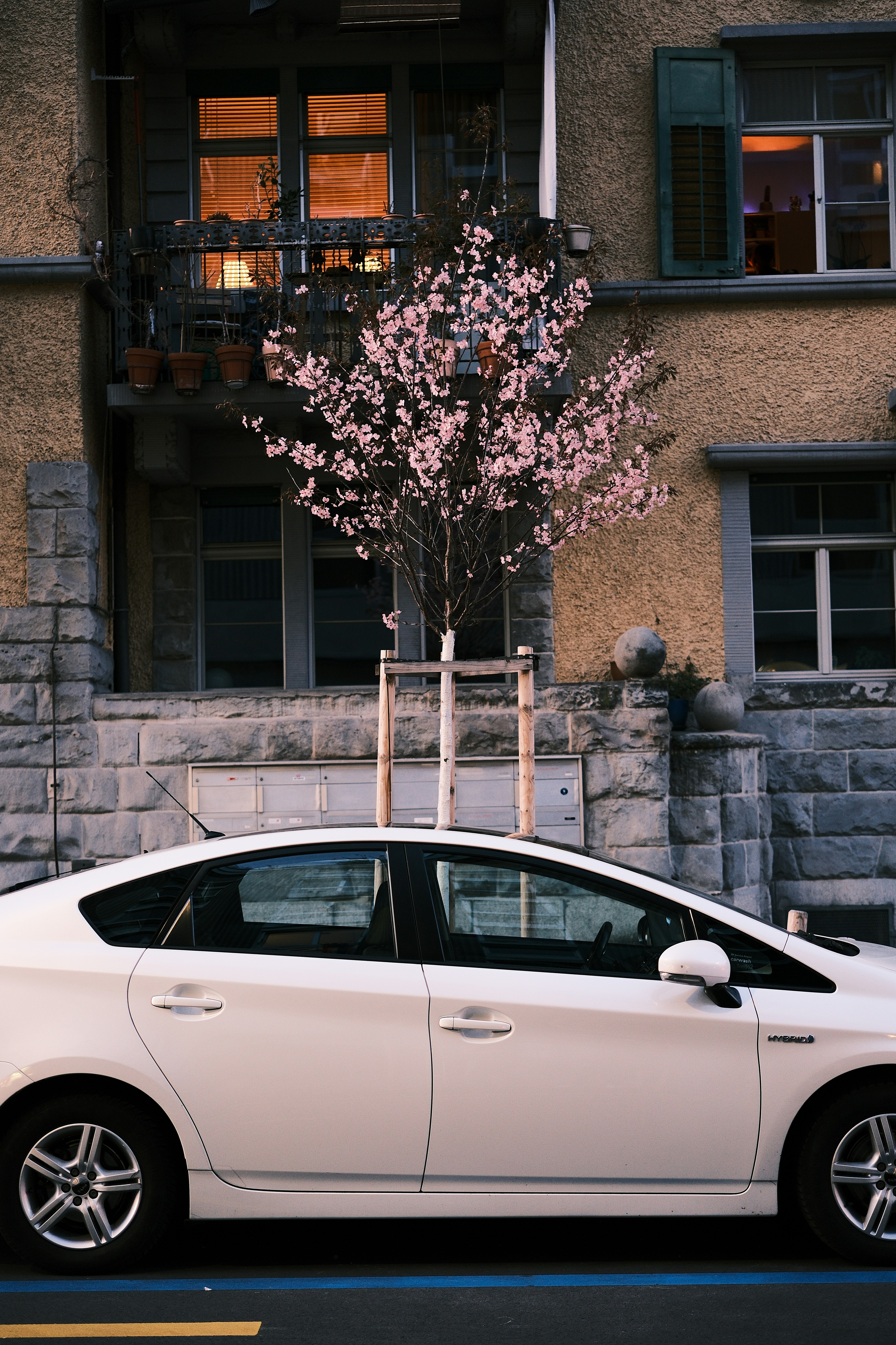 a white car parked in front of a tall building
