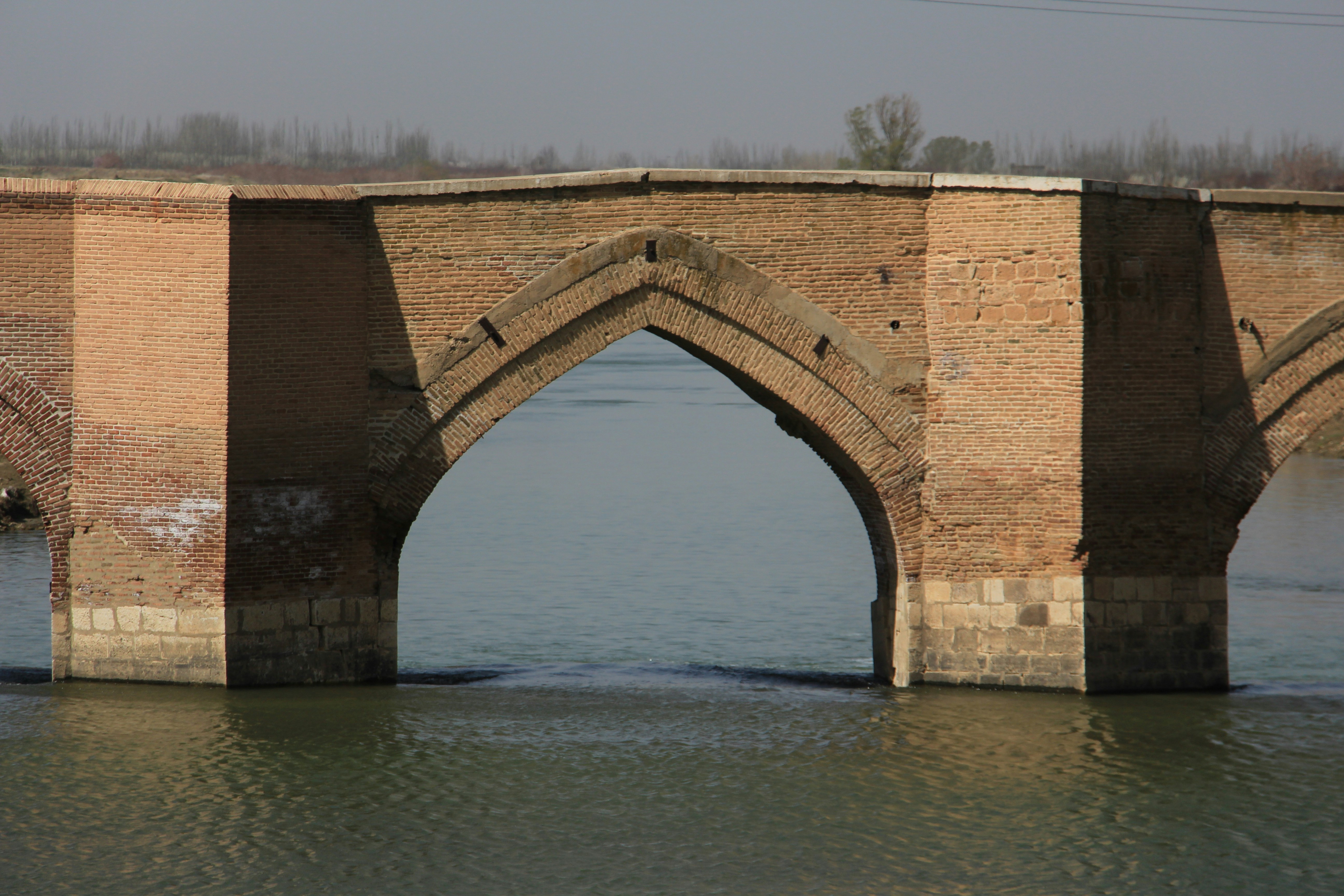 An old brick bridge over a body of water photo – Free Arch Image on ...