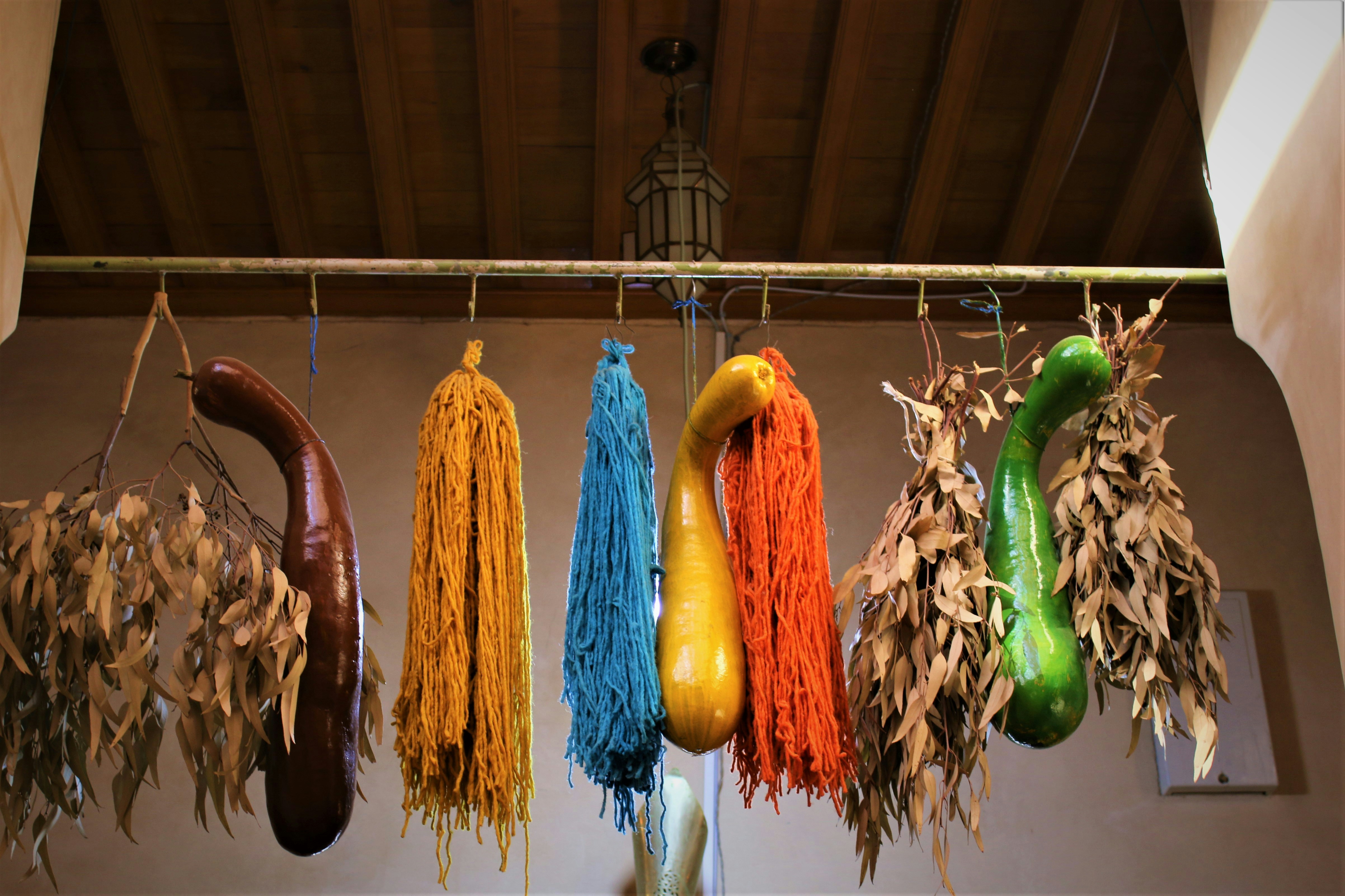 Chromatic Dangles: Colorful Tassels and Gourds in a Rustic Display