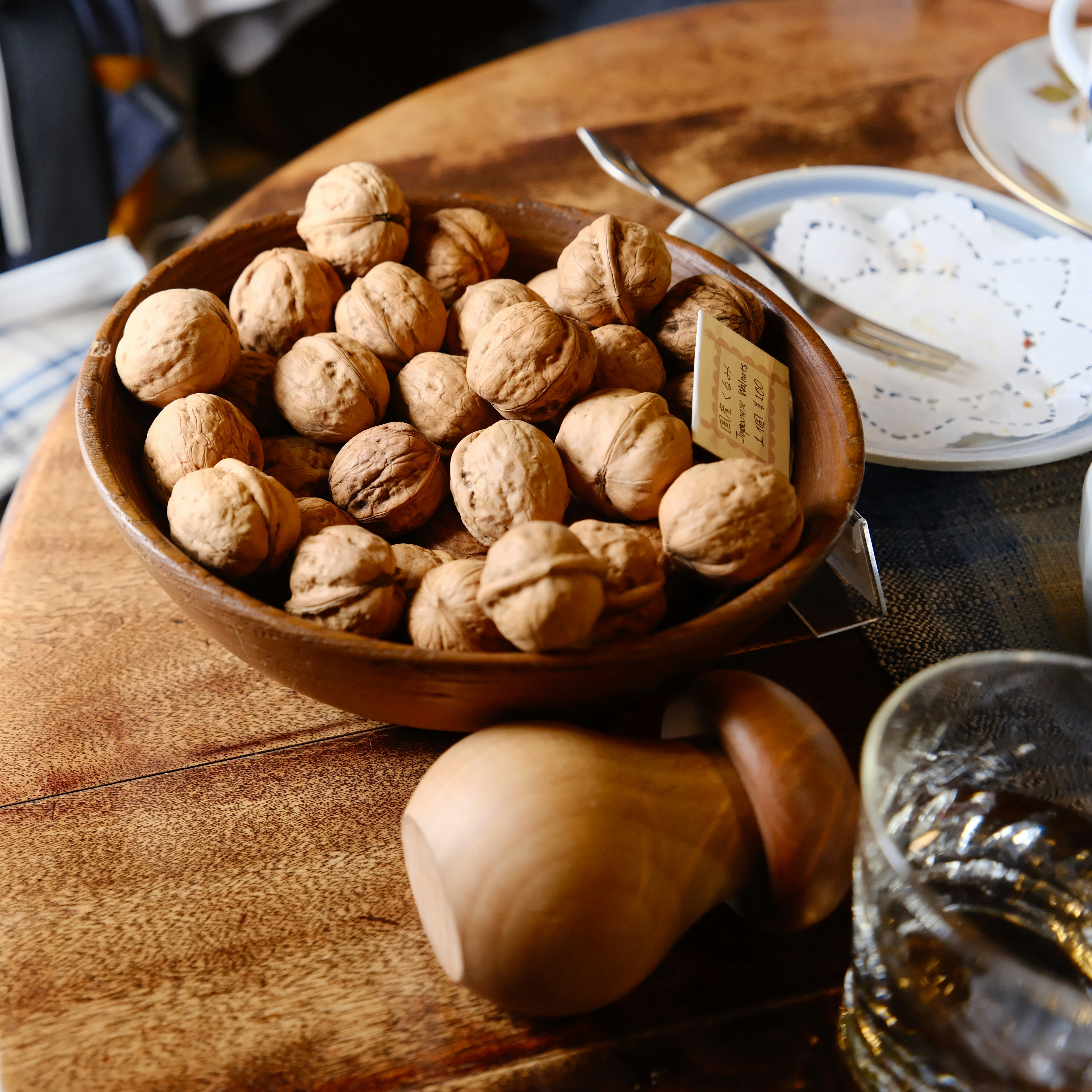 a bowl of walnuts on a wooden table