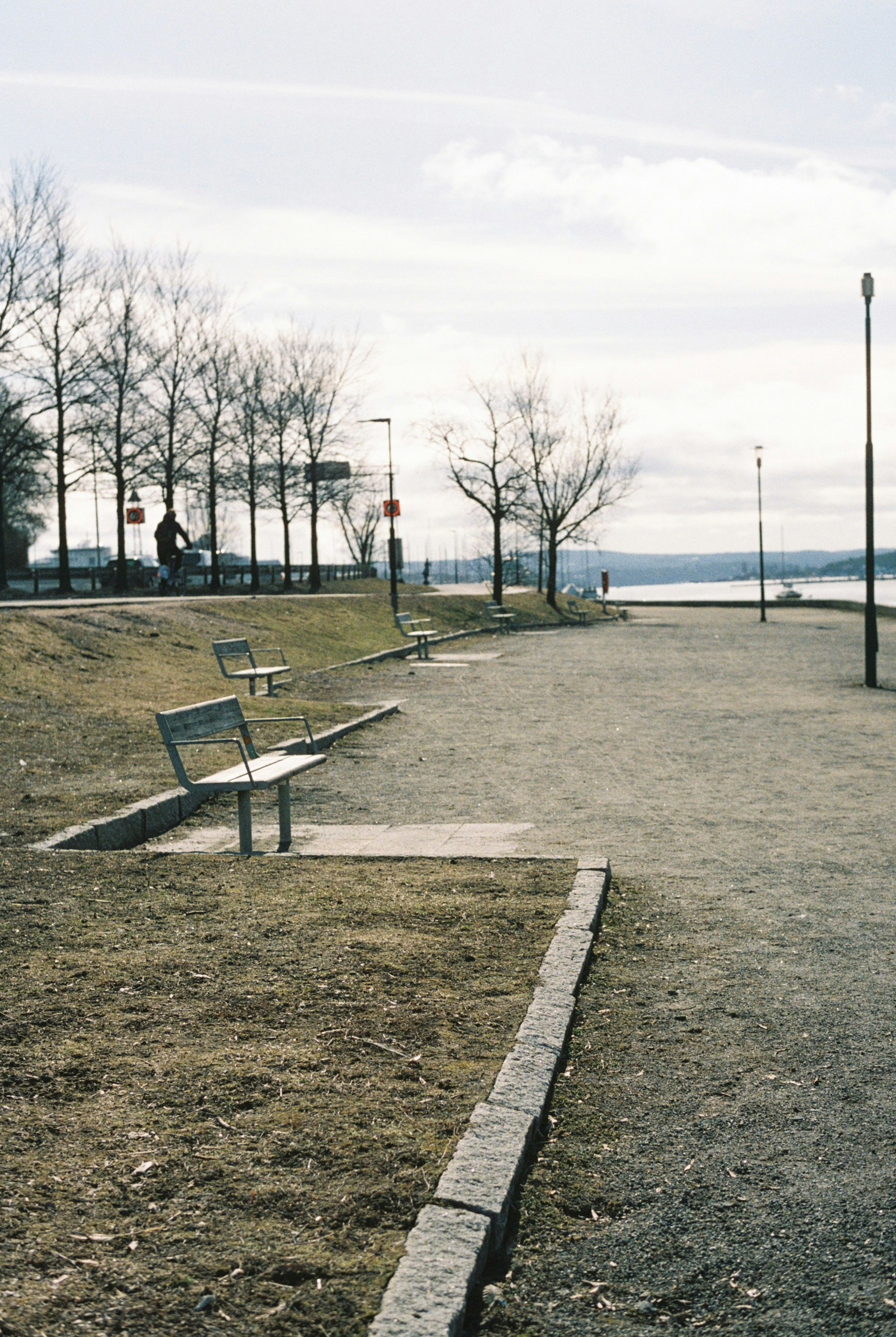A couple of benches sitting on top of a grass covered field photo ...