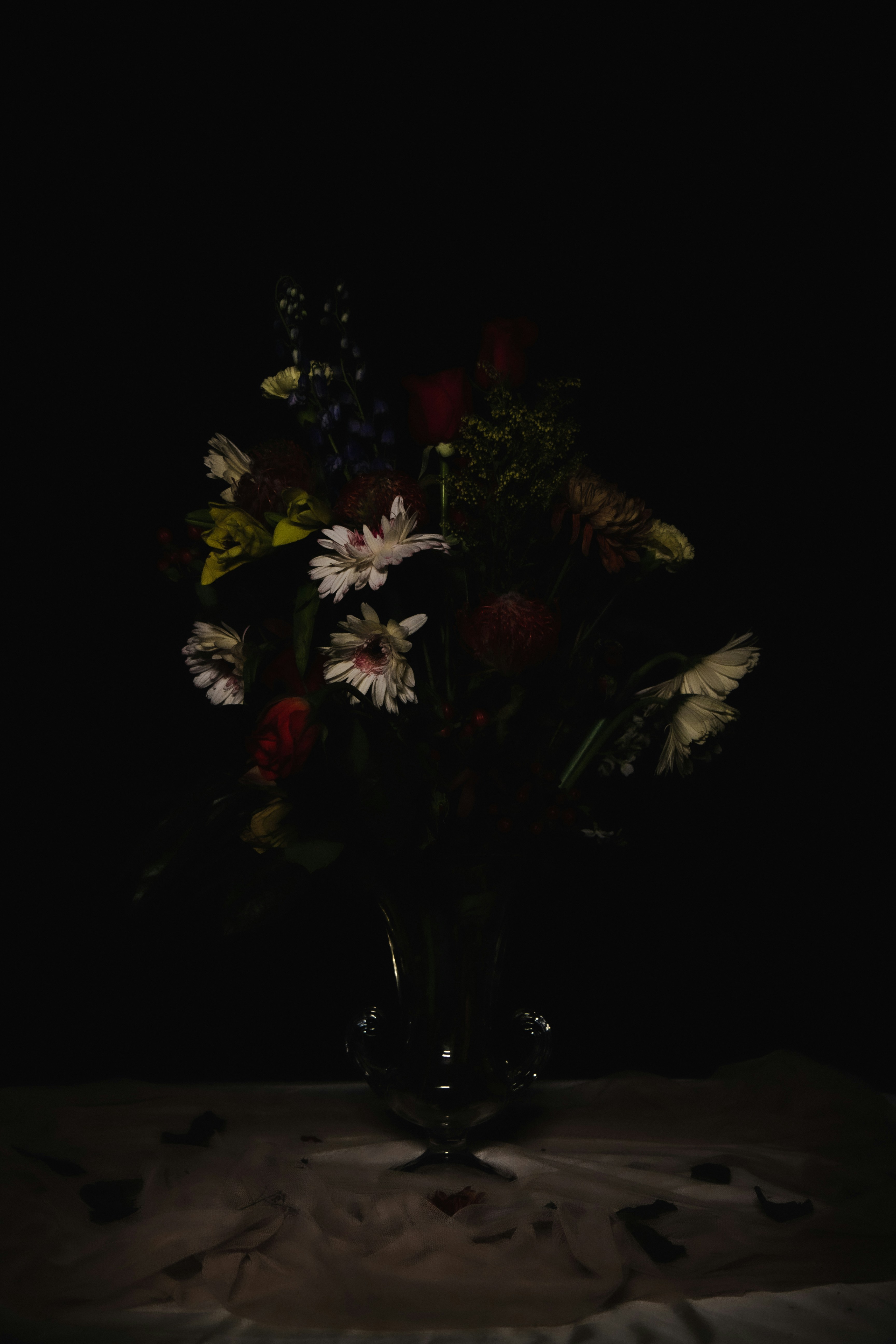 a vase filled with lots of flowers on top of a table