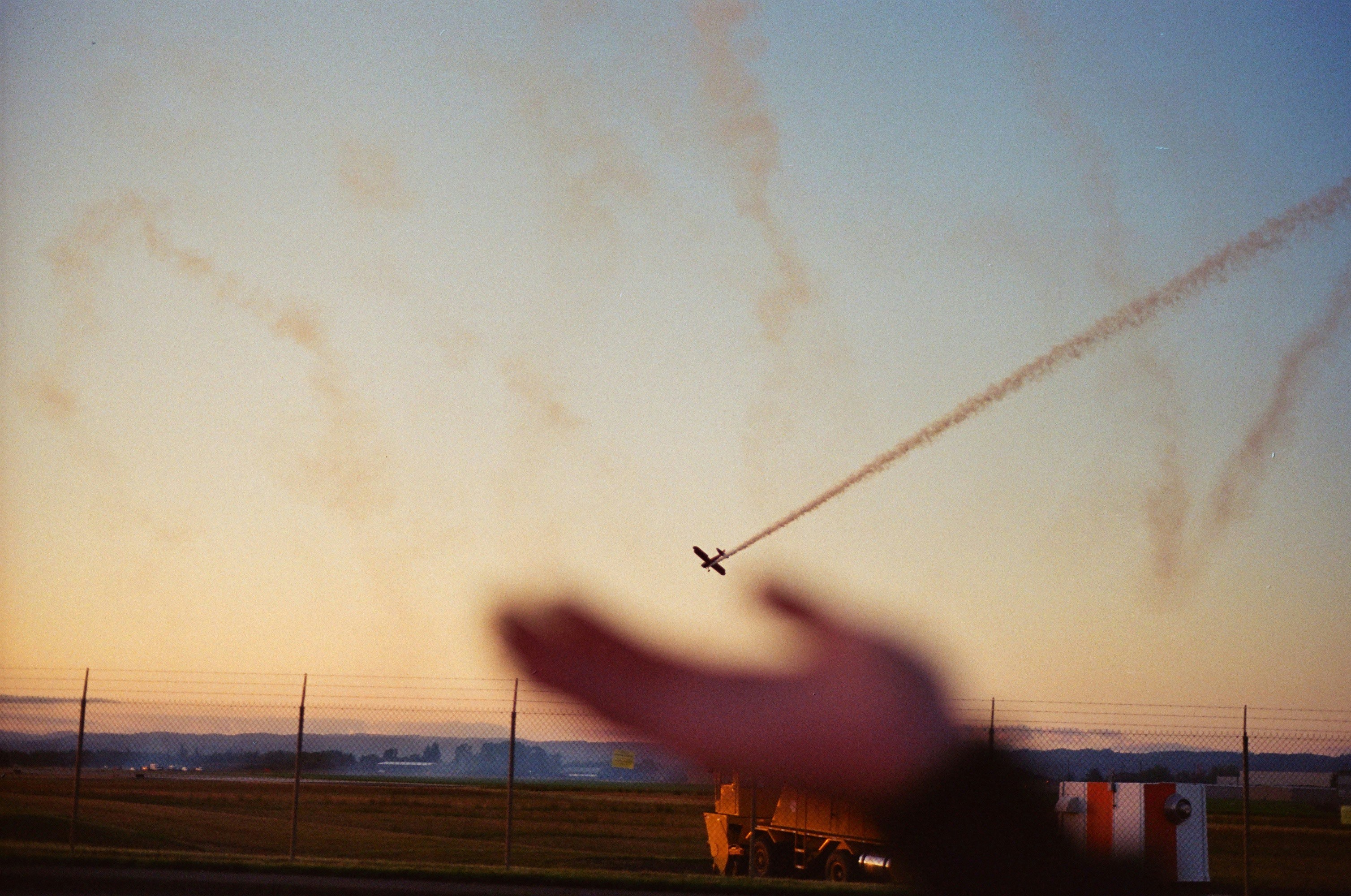 A plane flying in the sky with smoke coming out of it photo – Free ...