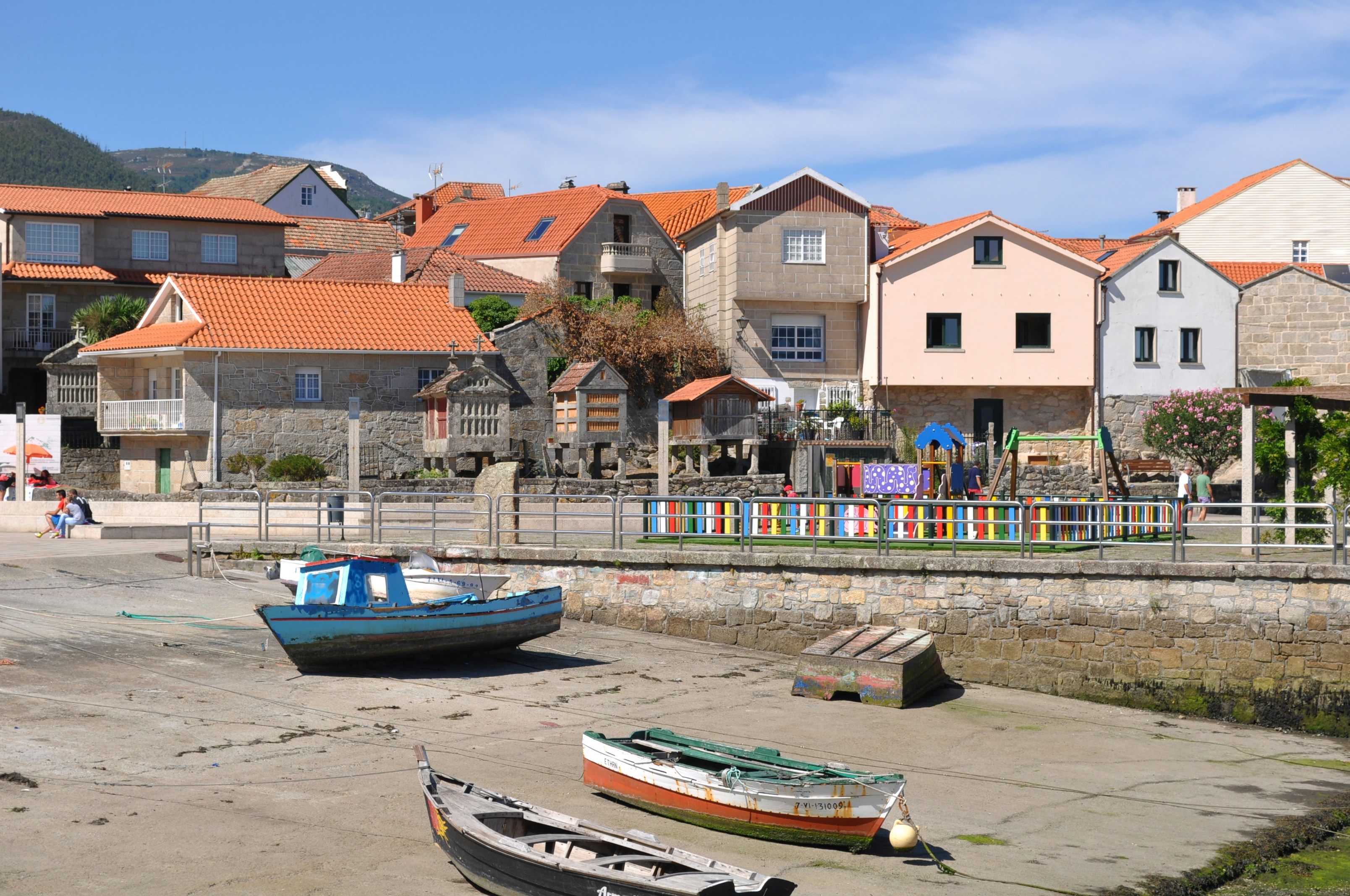 Blue Boat and Coral Rooftops: A Sunlit Harbor Village