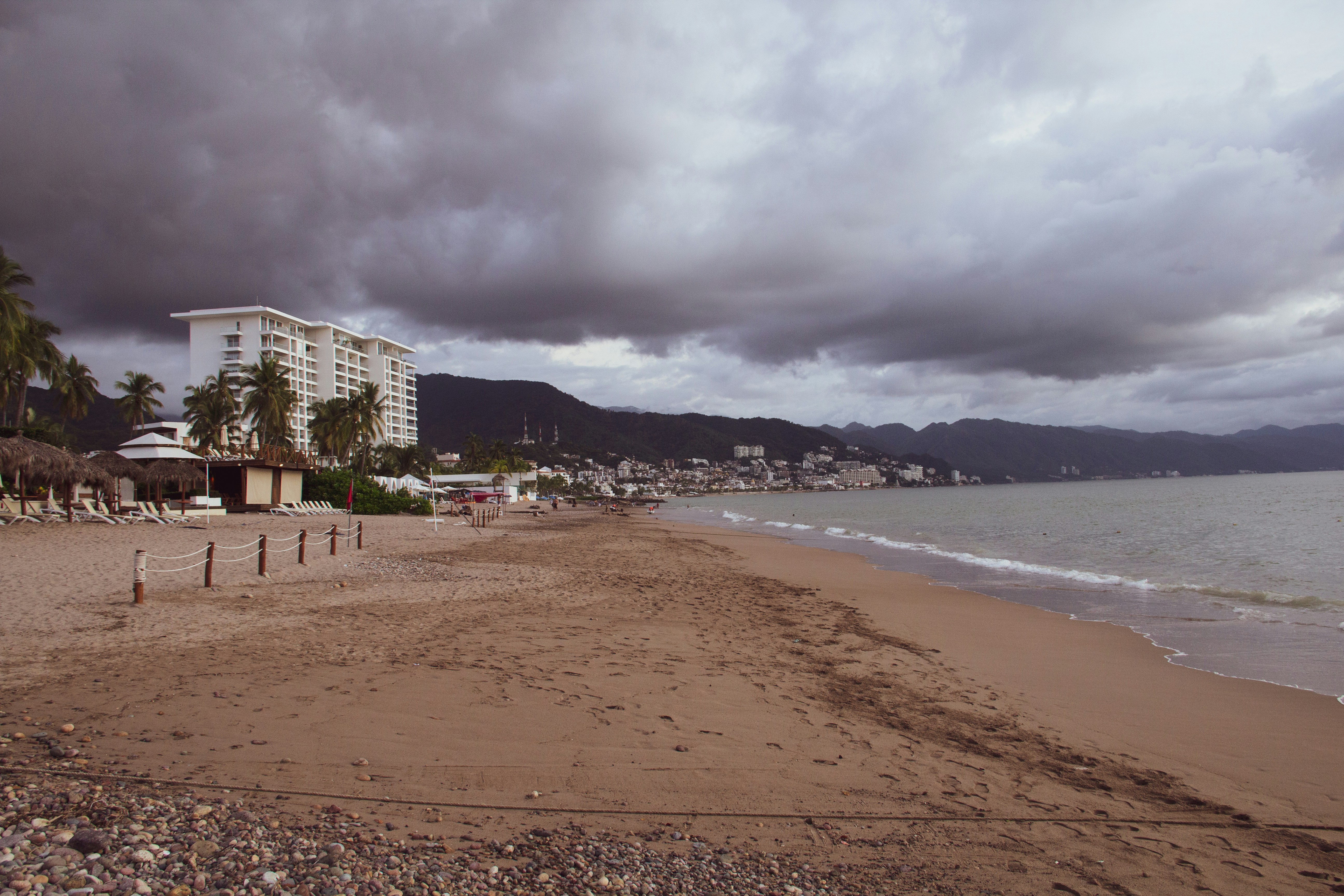 White Towers Under a Tempest: Beachfront Calm Meets Looming Clouds