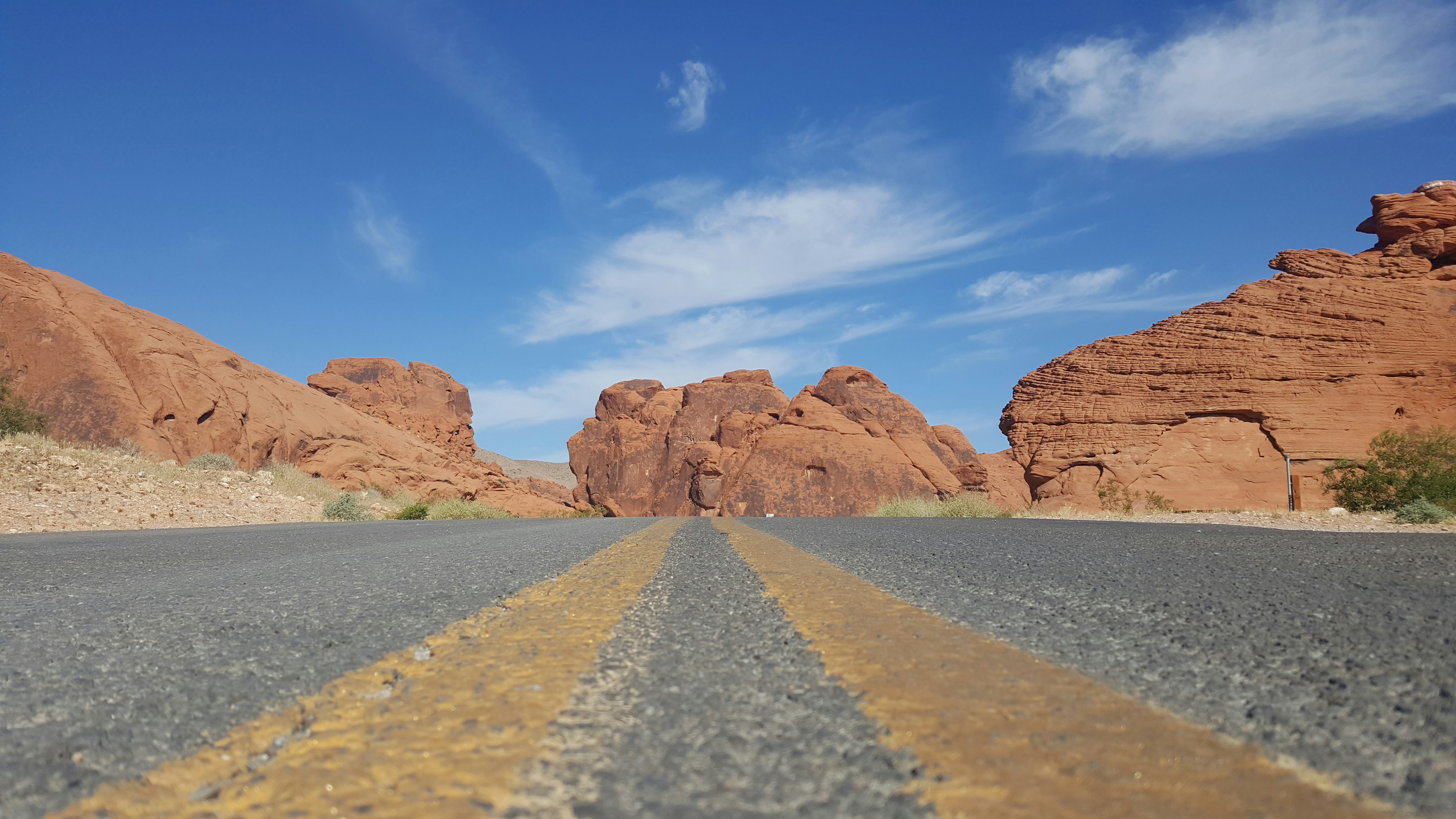 Low-Angle Road Through Red Rock Giants Beneath a Cerulean Sky
