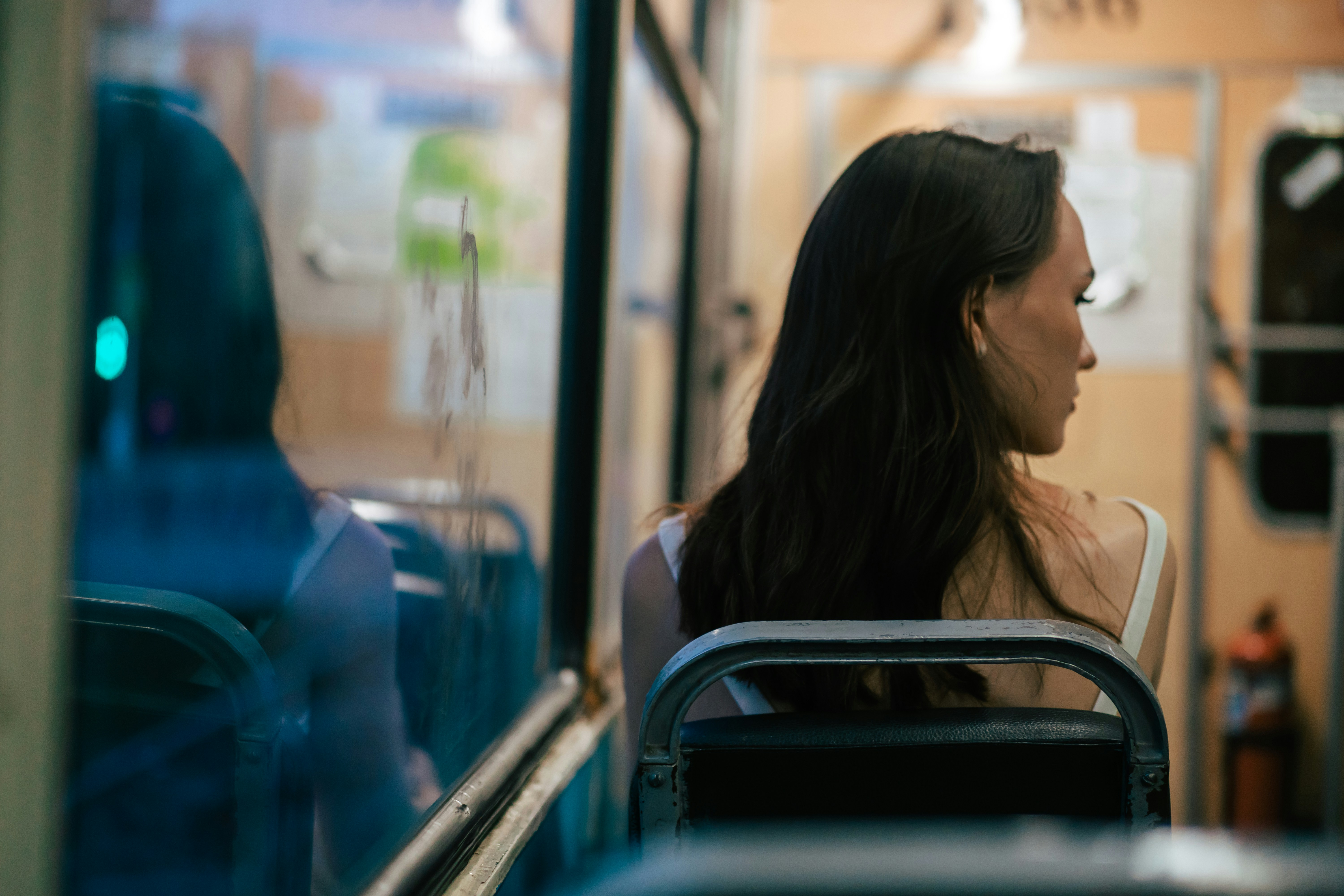 A woman sitting on a bus looking out the window photo – Free Girl Image ...