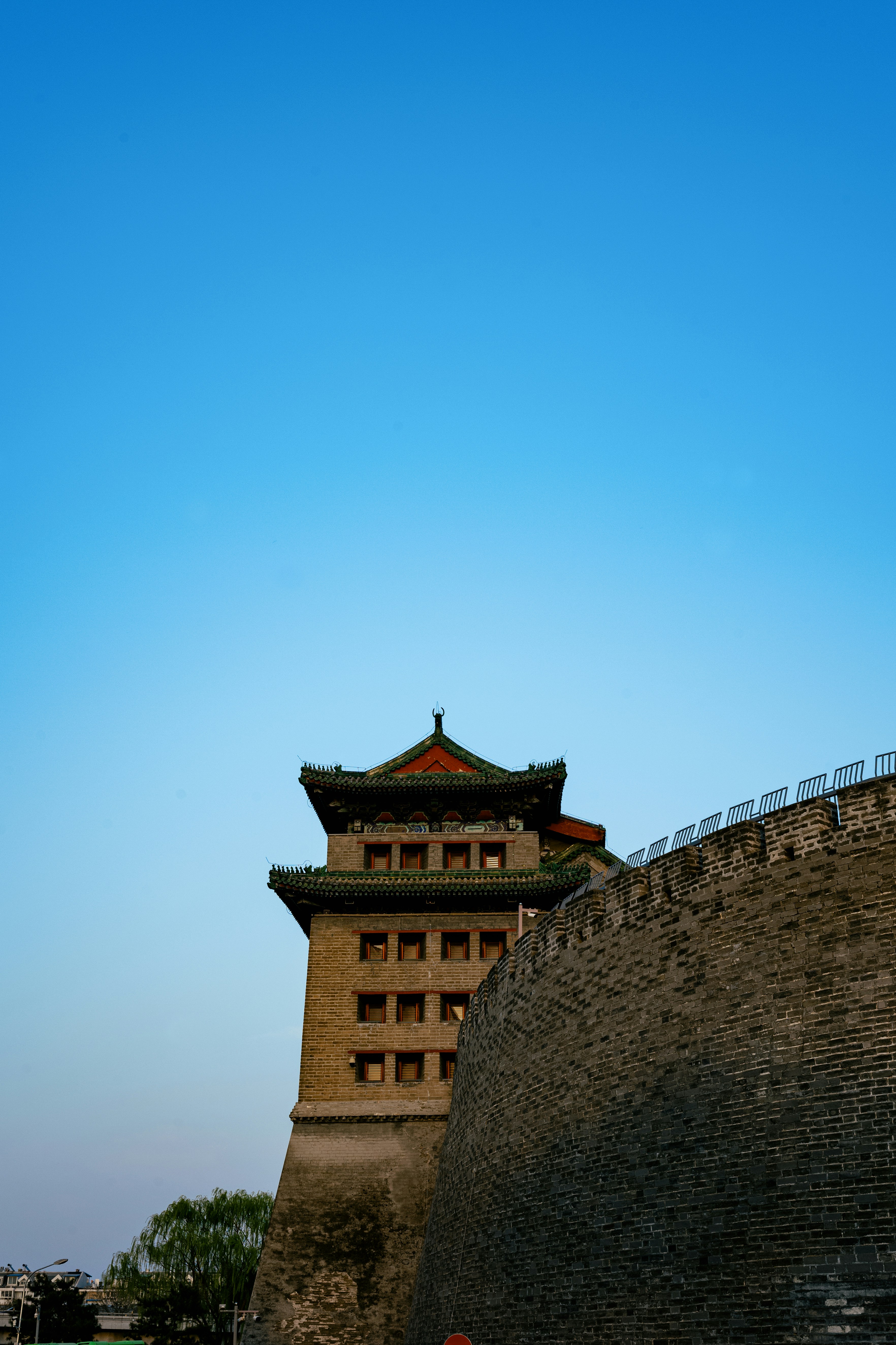 A tall brick wall with a tower in the background photo – Free Image on ...