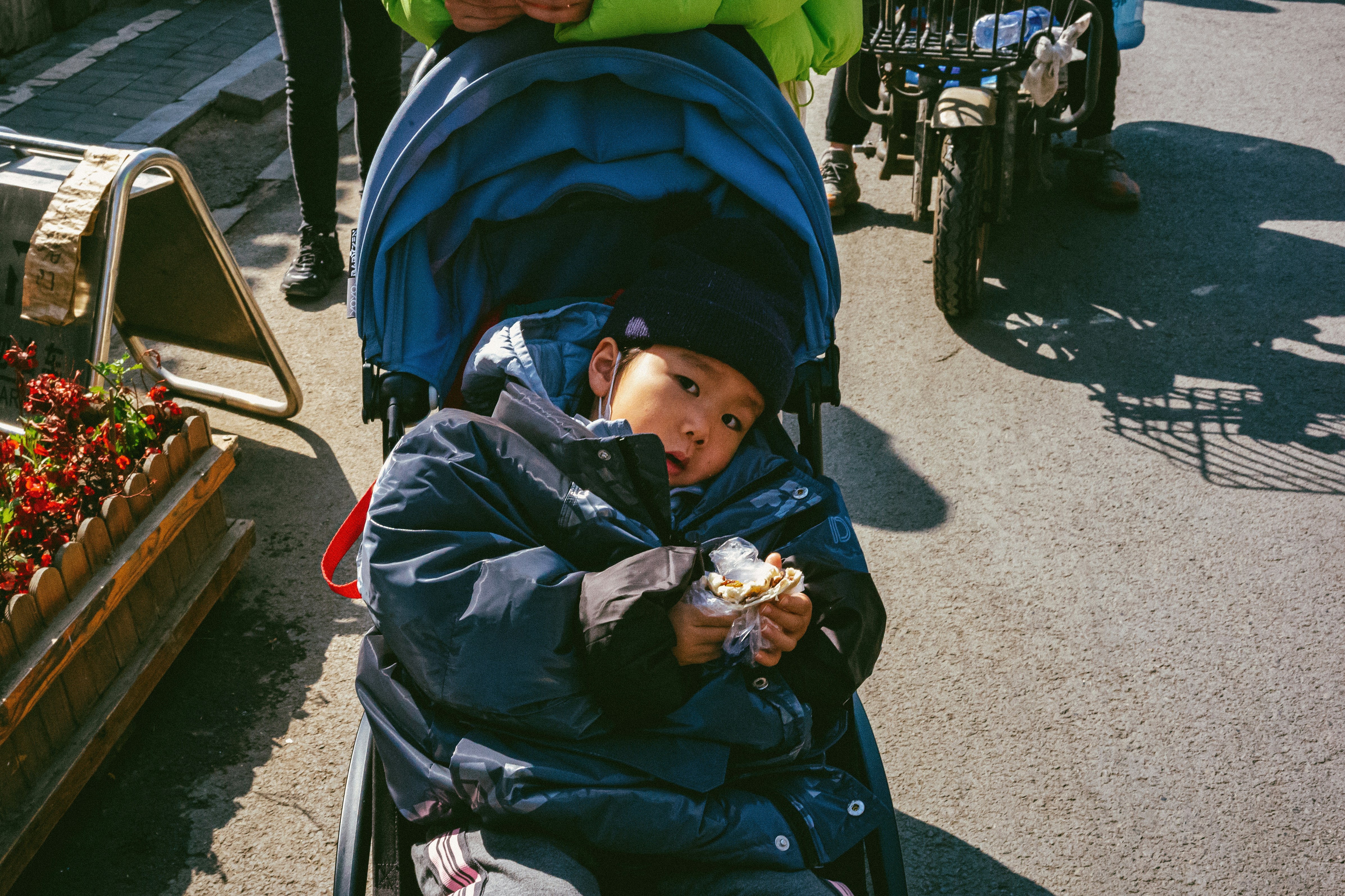 Warmth in Navy: a quiet bite on a sunlit sidewalk
