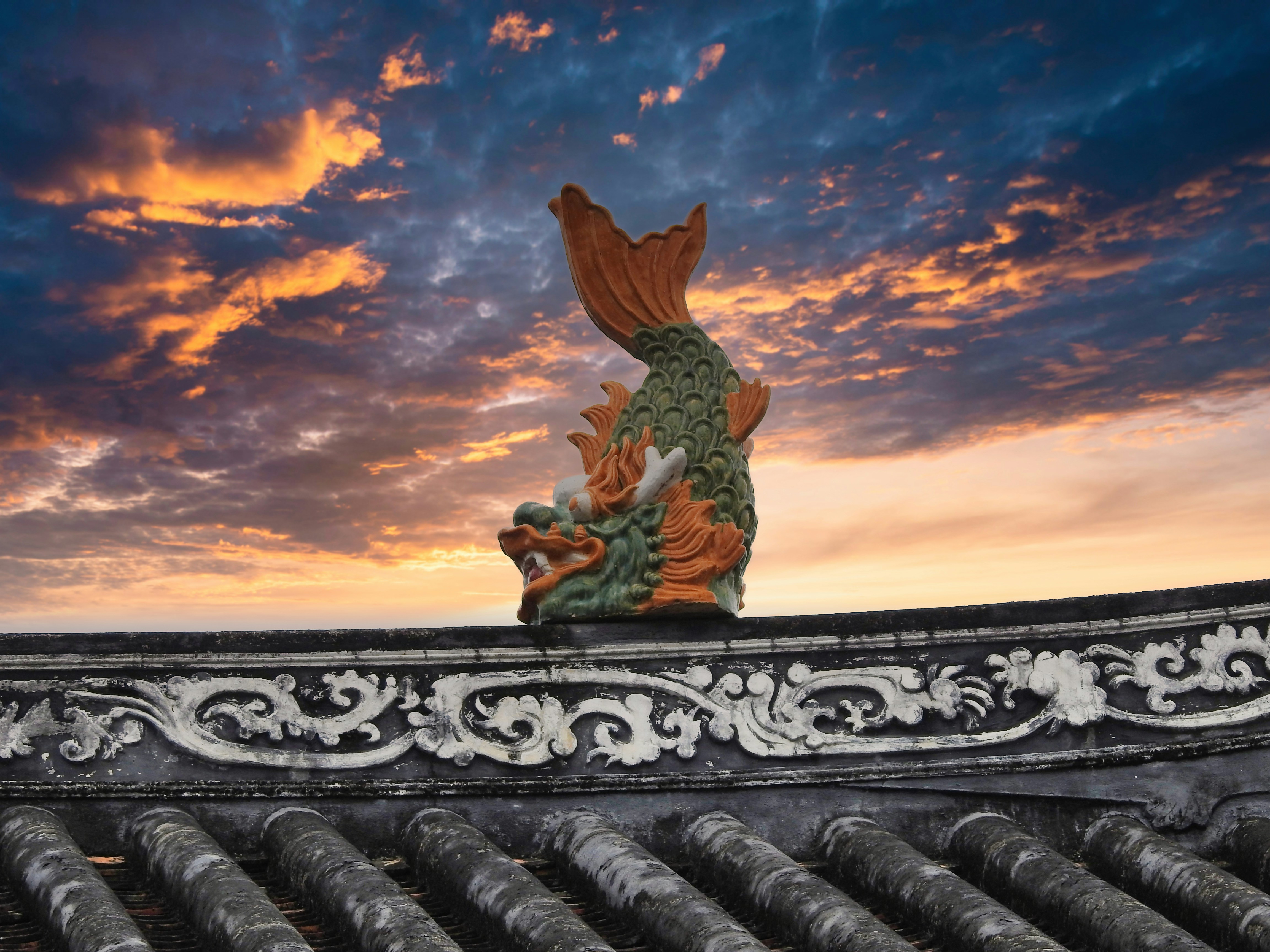 a statue of a fish on top of a roof