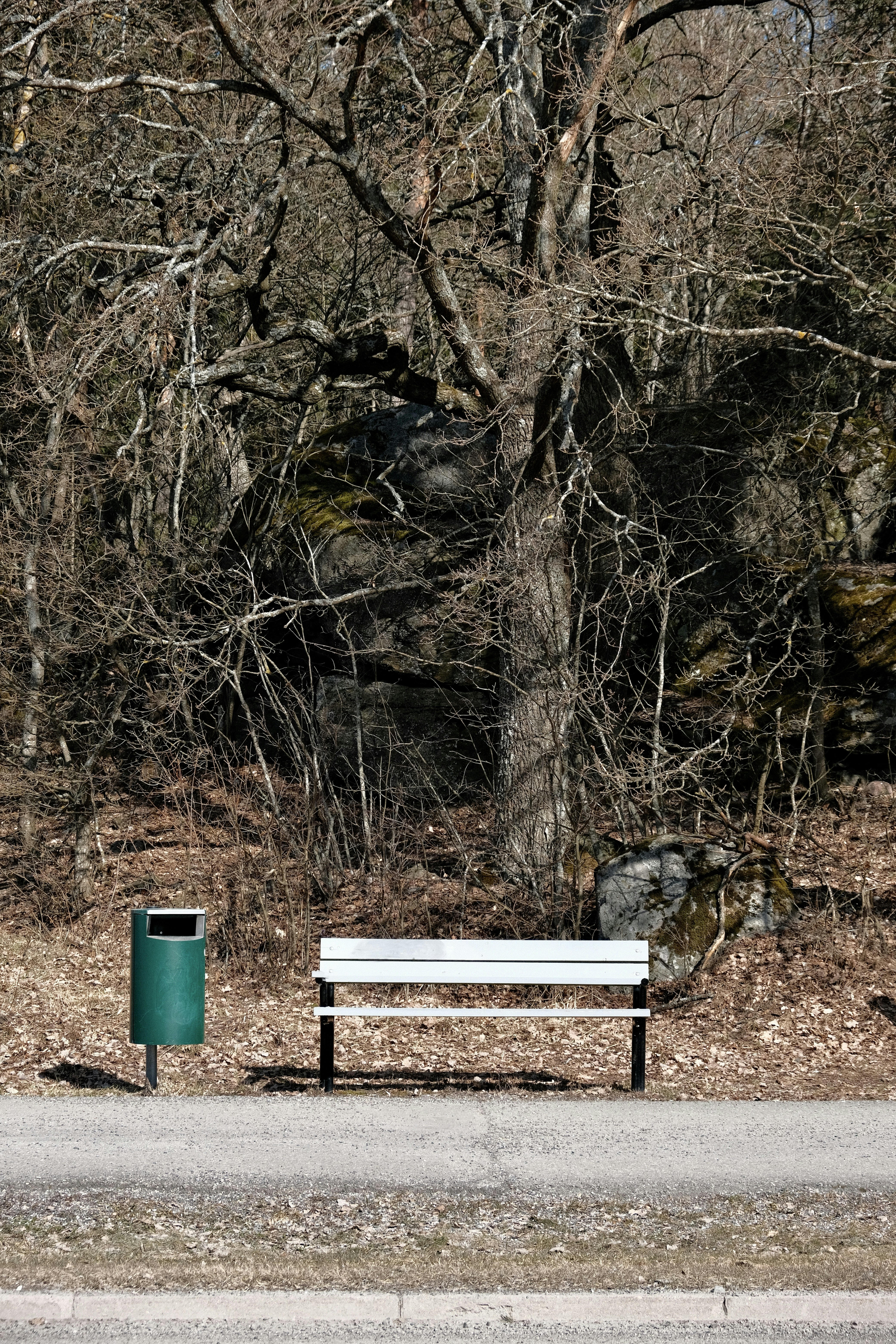 a white bench sitting on the side of a road