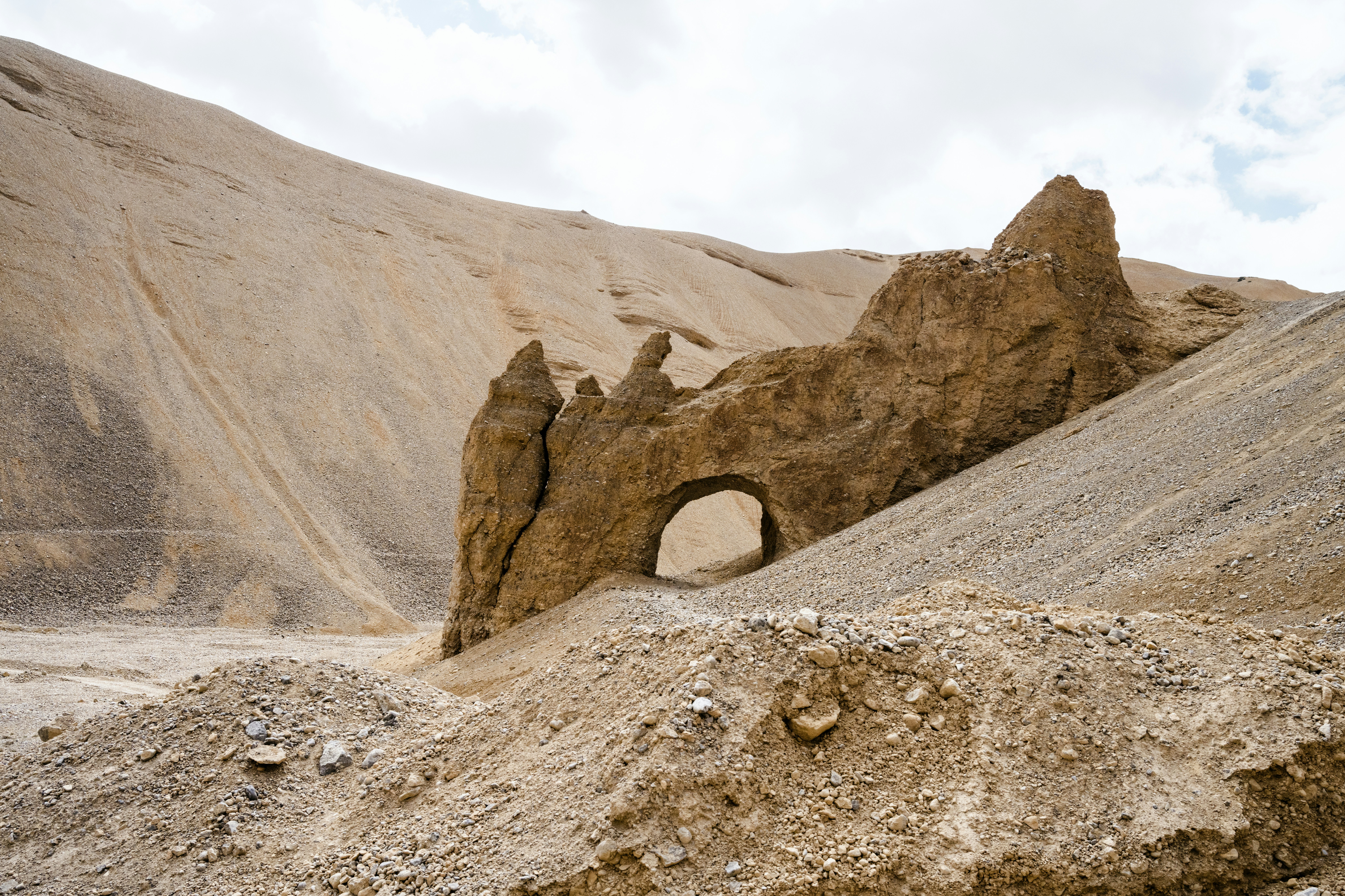 Desert Stone Arch: a wind-sculpted gateway amid eroded clay hills