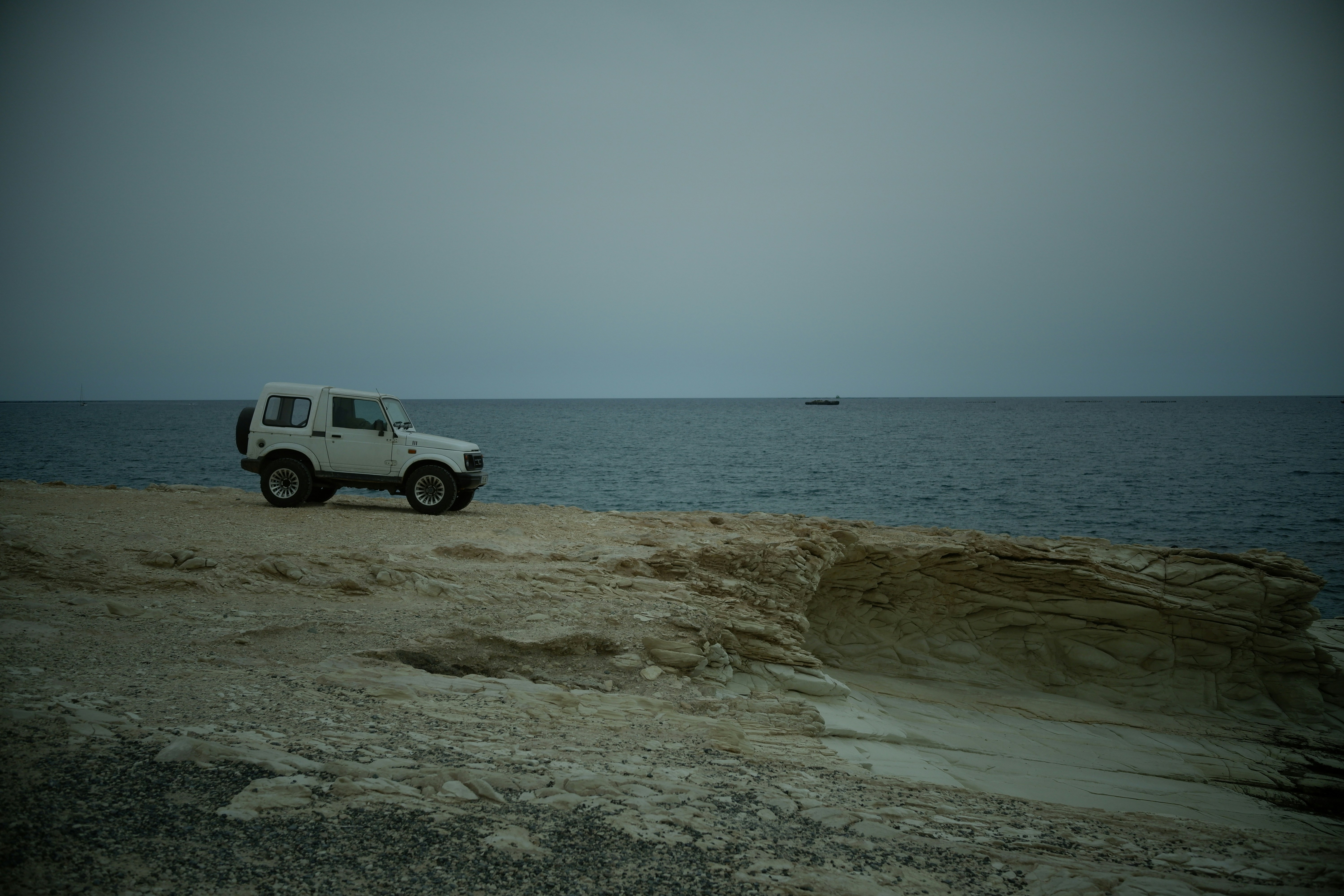 a truck is parked on the beach near the water
