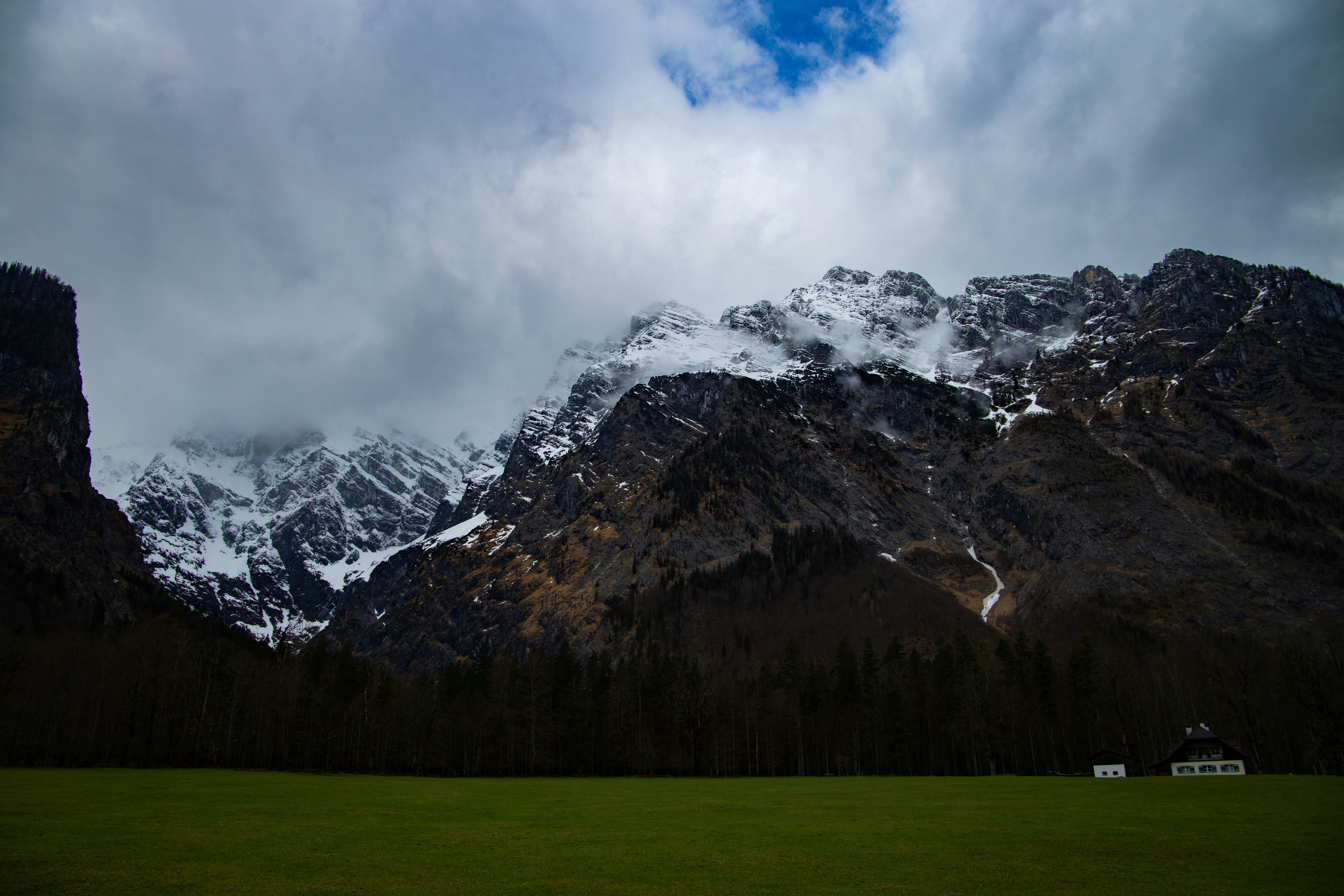Snow-kissed ridges above a quiet green valley