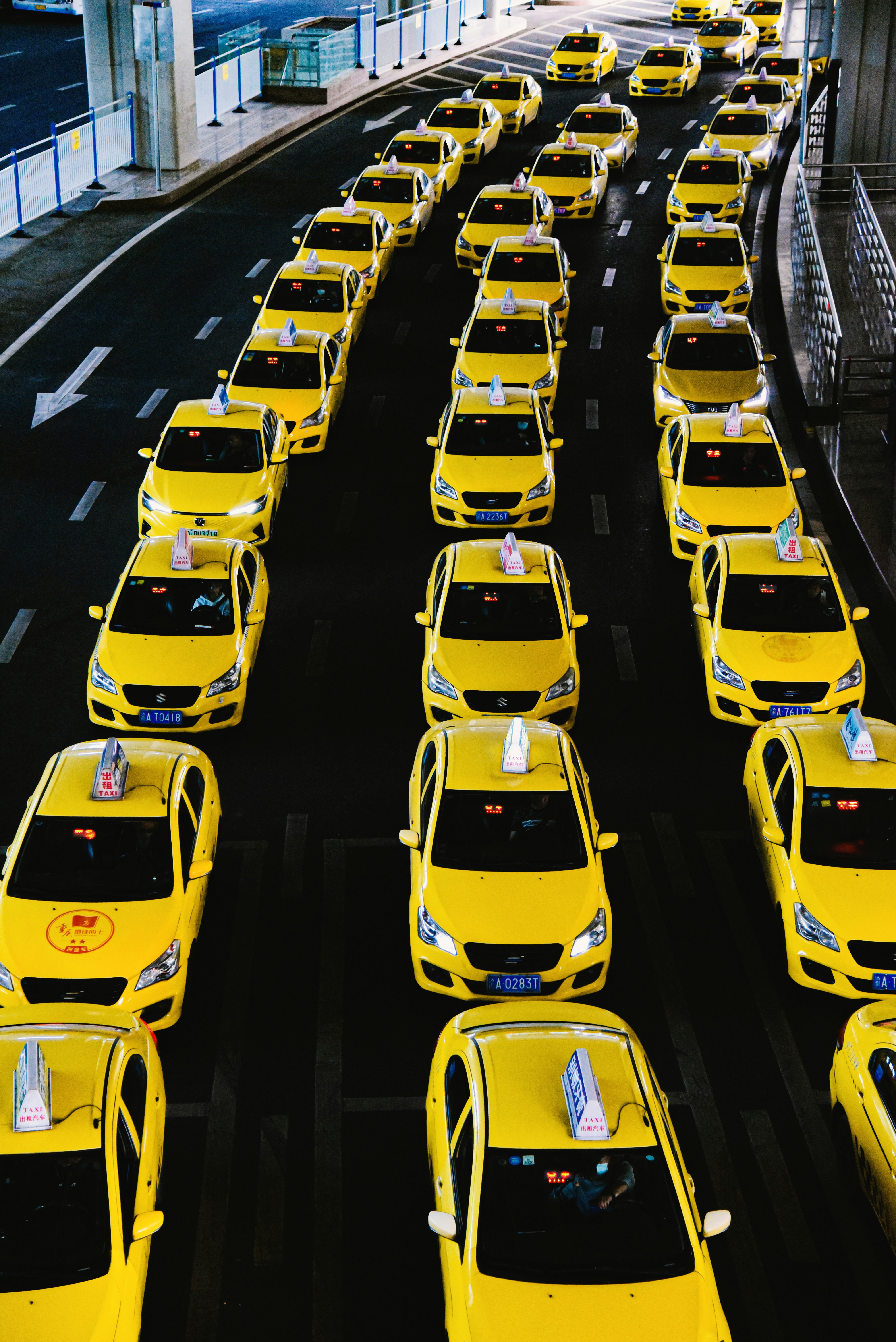 A long line of yellow taxi cabs on a highway photo – Free Taxi Image on ...