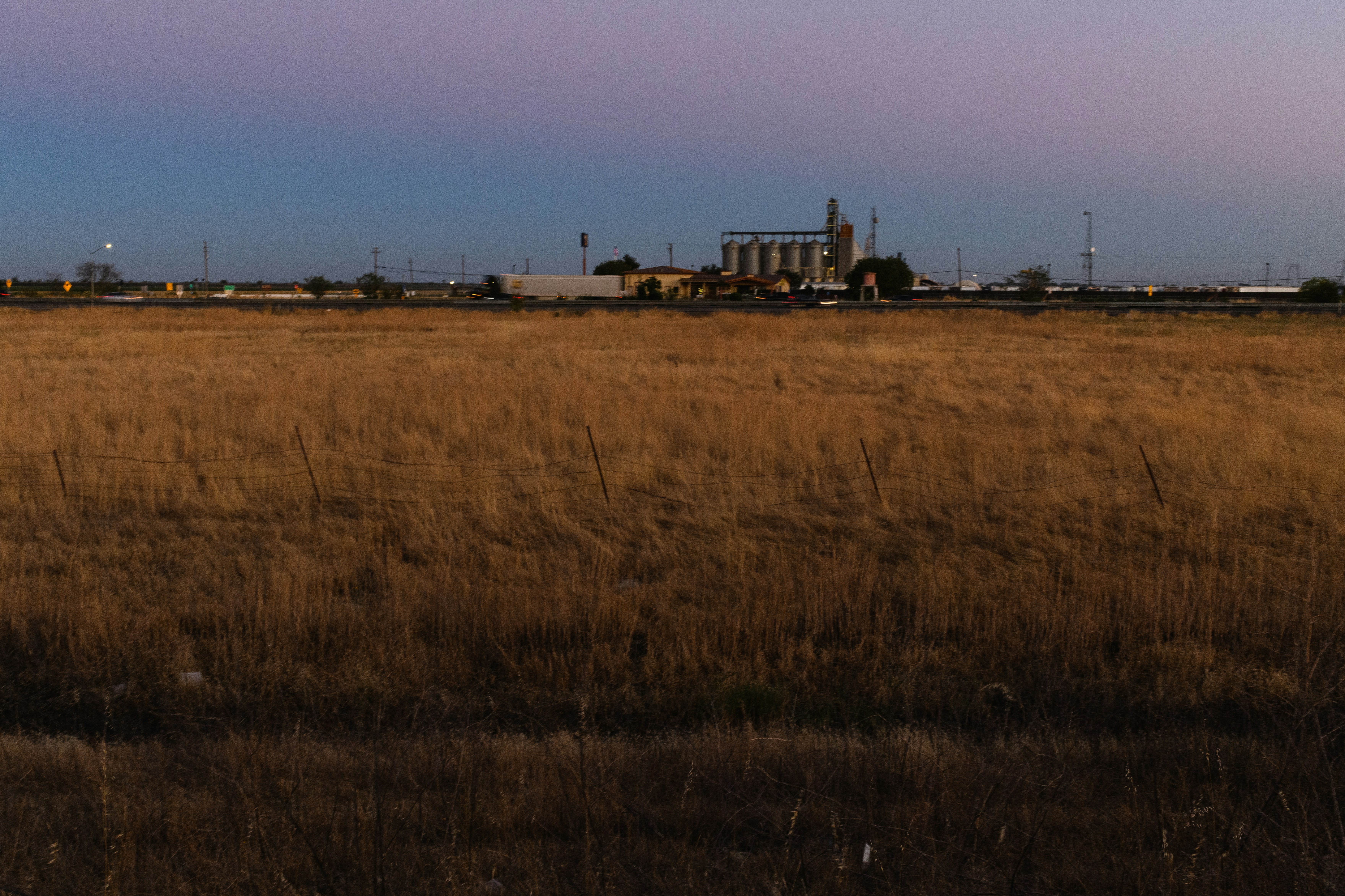 A large field with a factory in the distance photo – Free Land Image on ...
