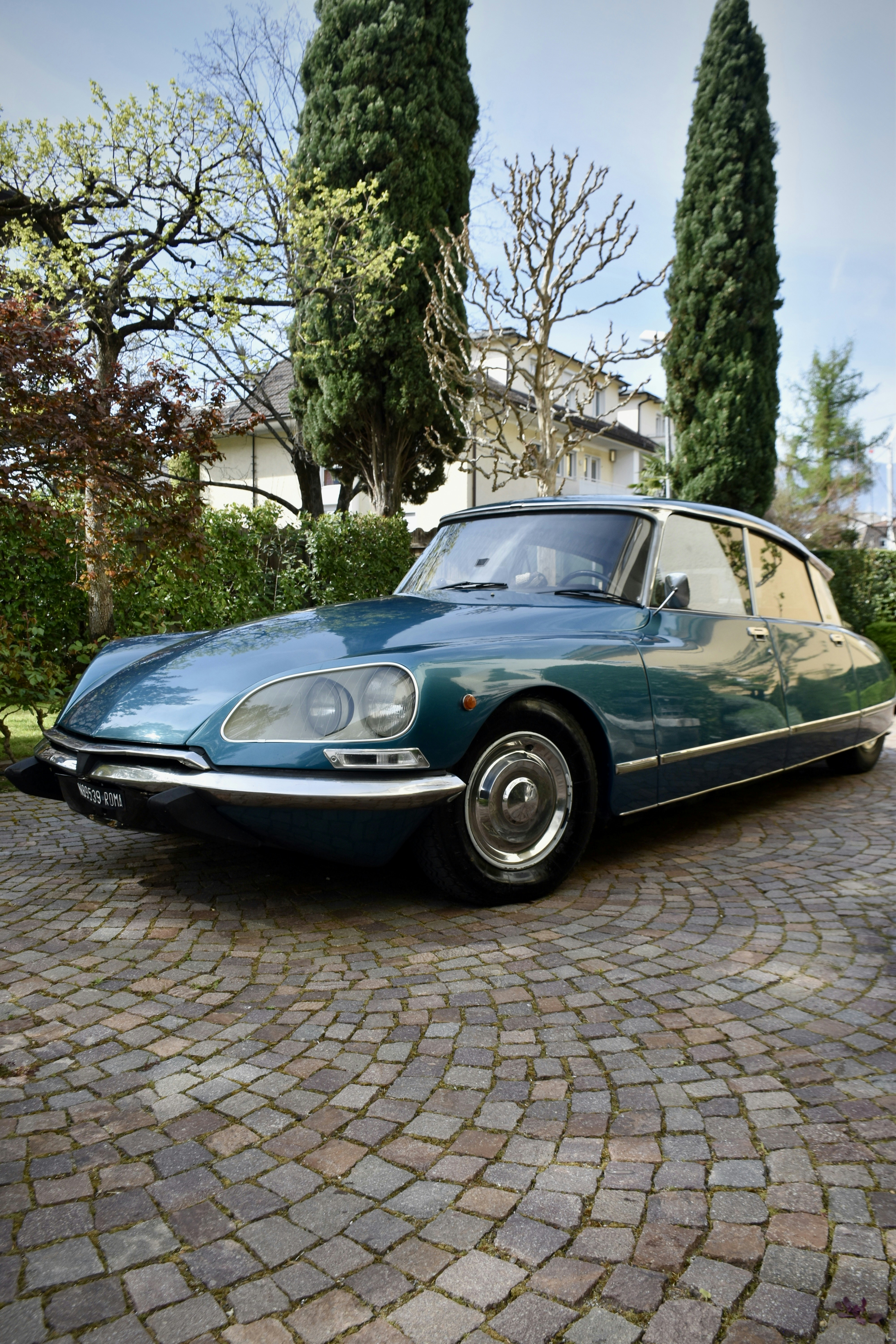 Teal Classic: A Vintage Citroën Waiting in a Cobblestone Drive