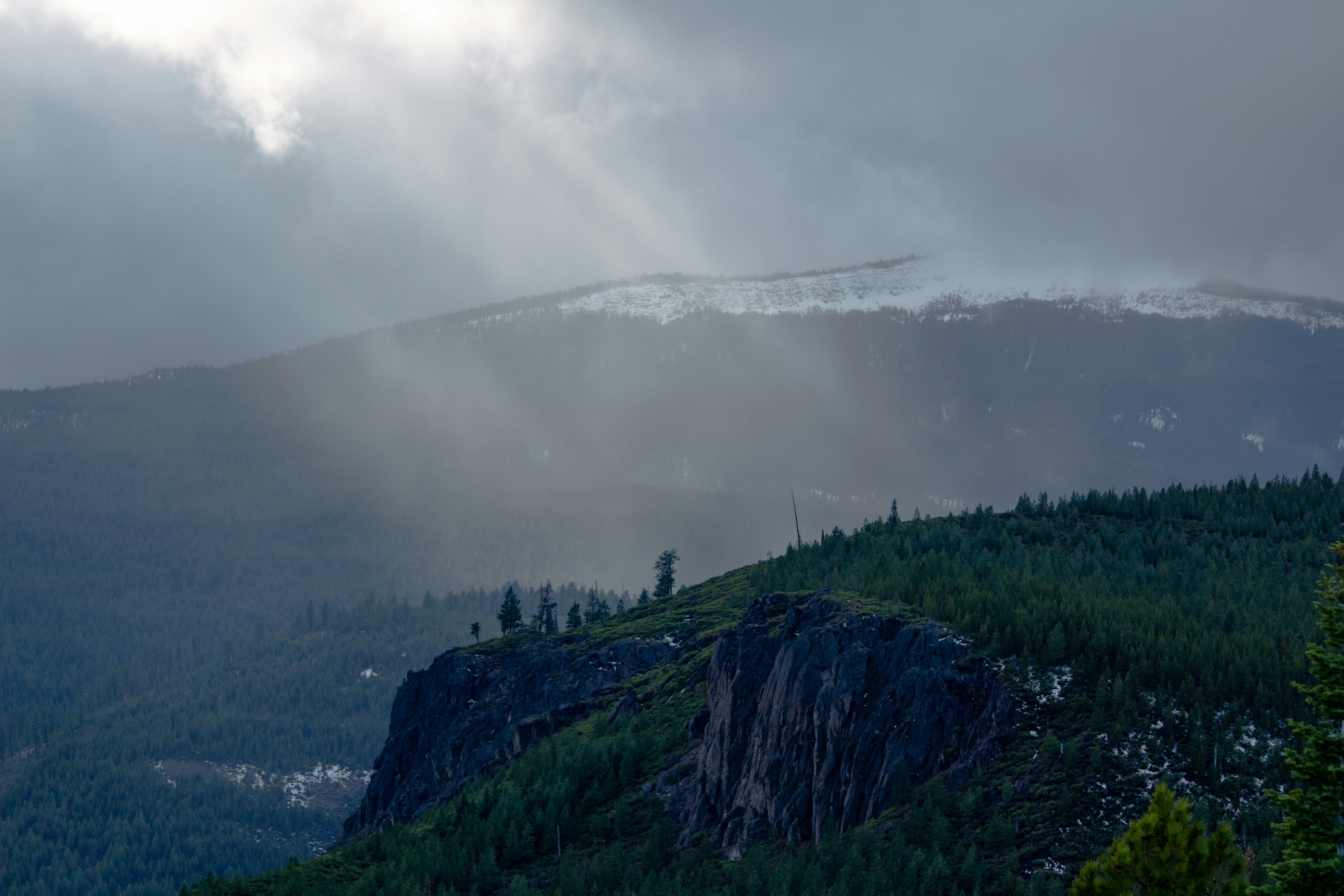 Cliffside Beacon: Narrow Sunbeams Piercing a Misty Ridge