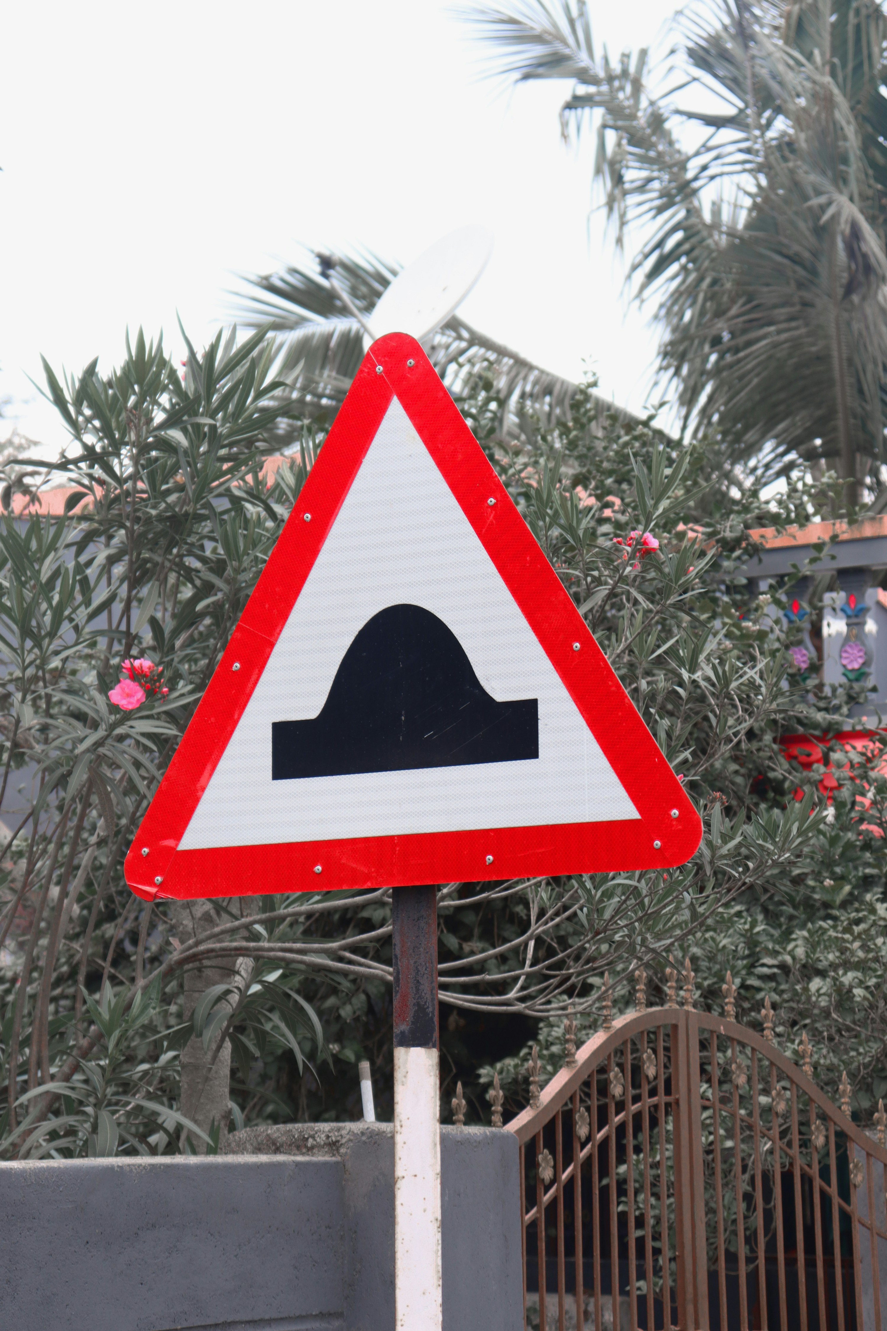 Foto Un letrero triangular rojo y blanco sentado junto a una cerca ...