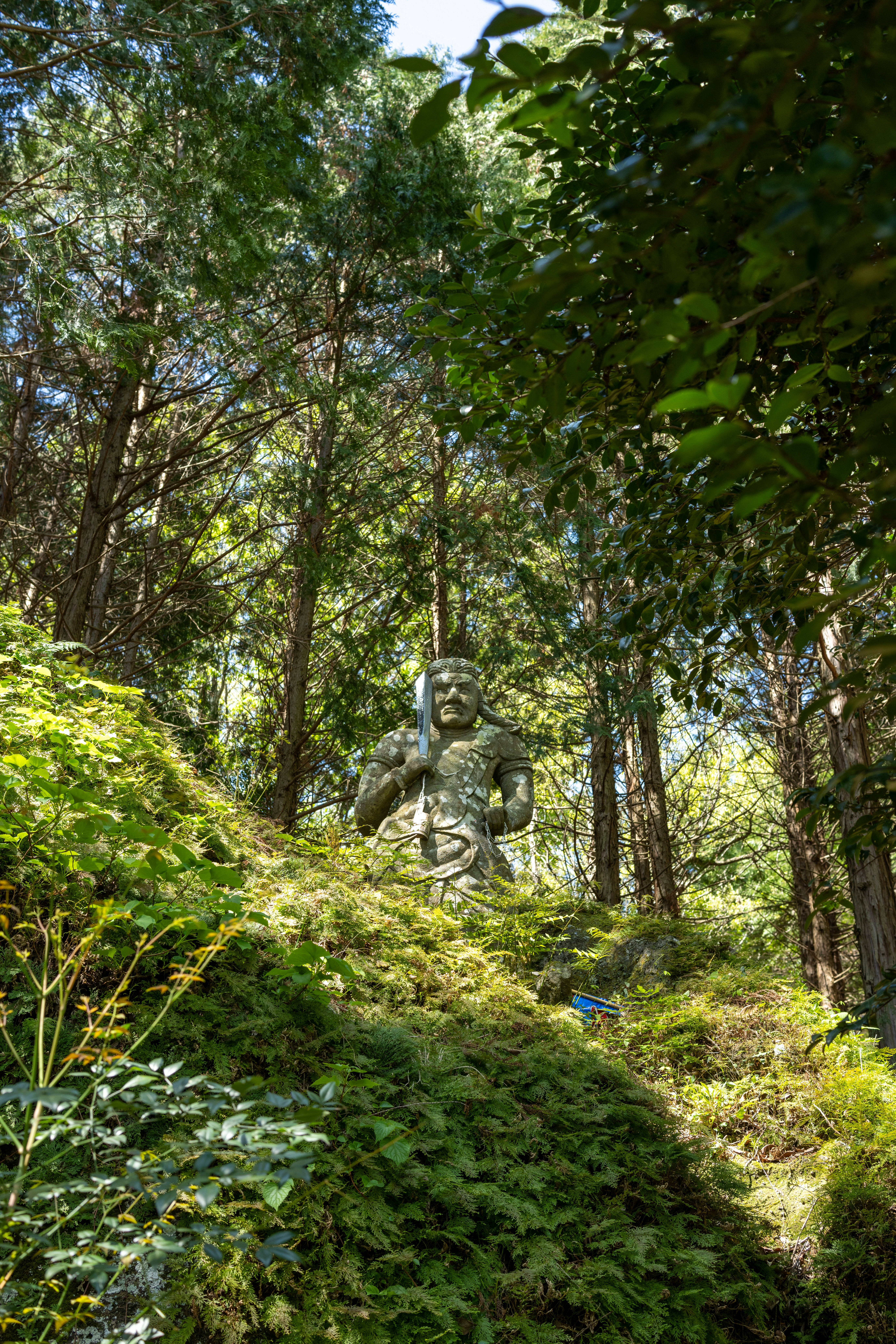 Forest Sentinel: A Moss-Covered Statue Guarding the Quiet Glade