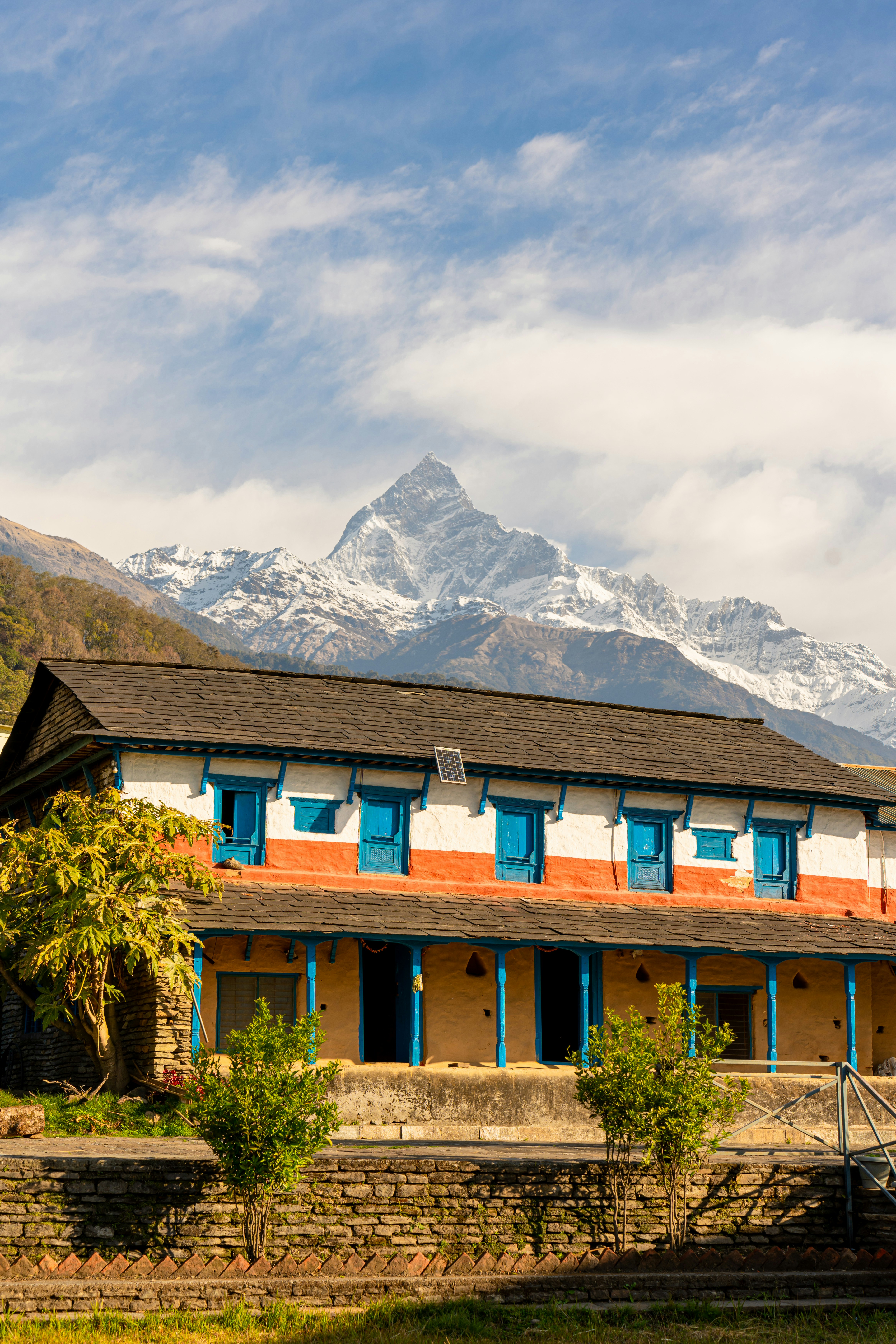 Blue-Walled Lodge at the Foot of Snowy Peaks