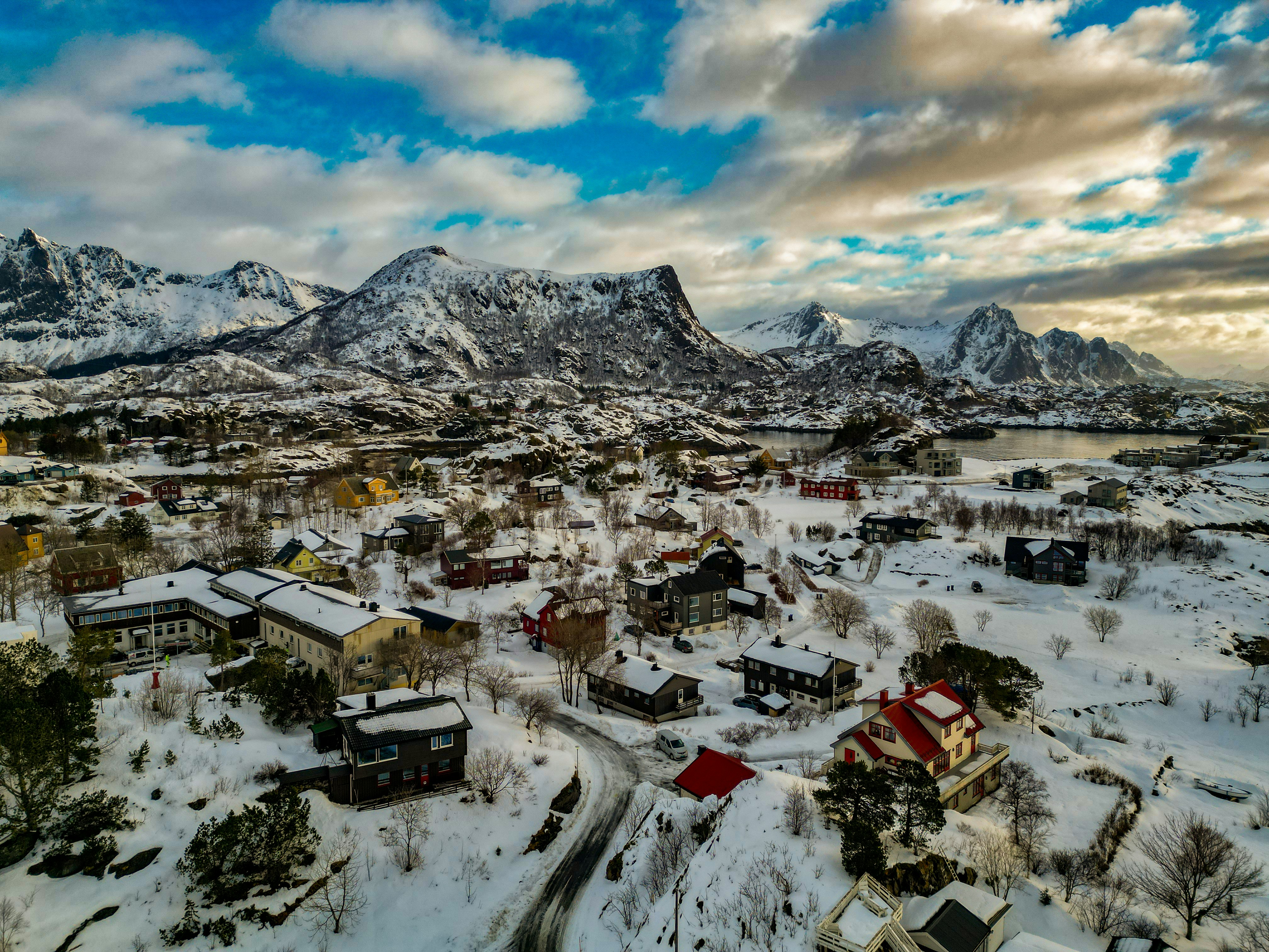 A little fishing town in Lofoten, Norway with snow covered mountains in the background. Taken with a drone.