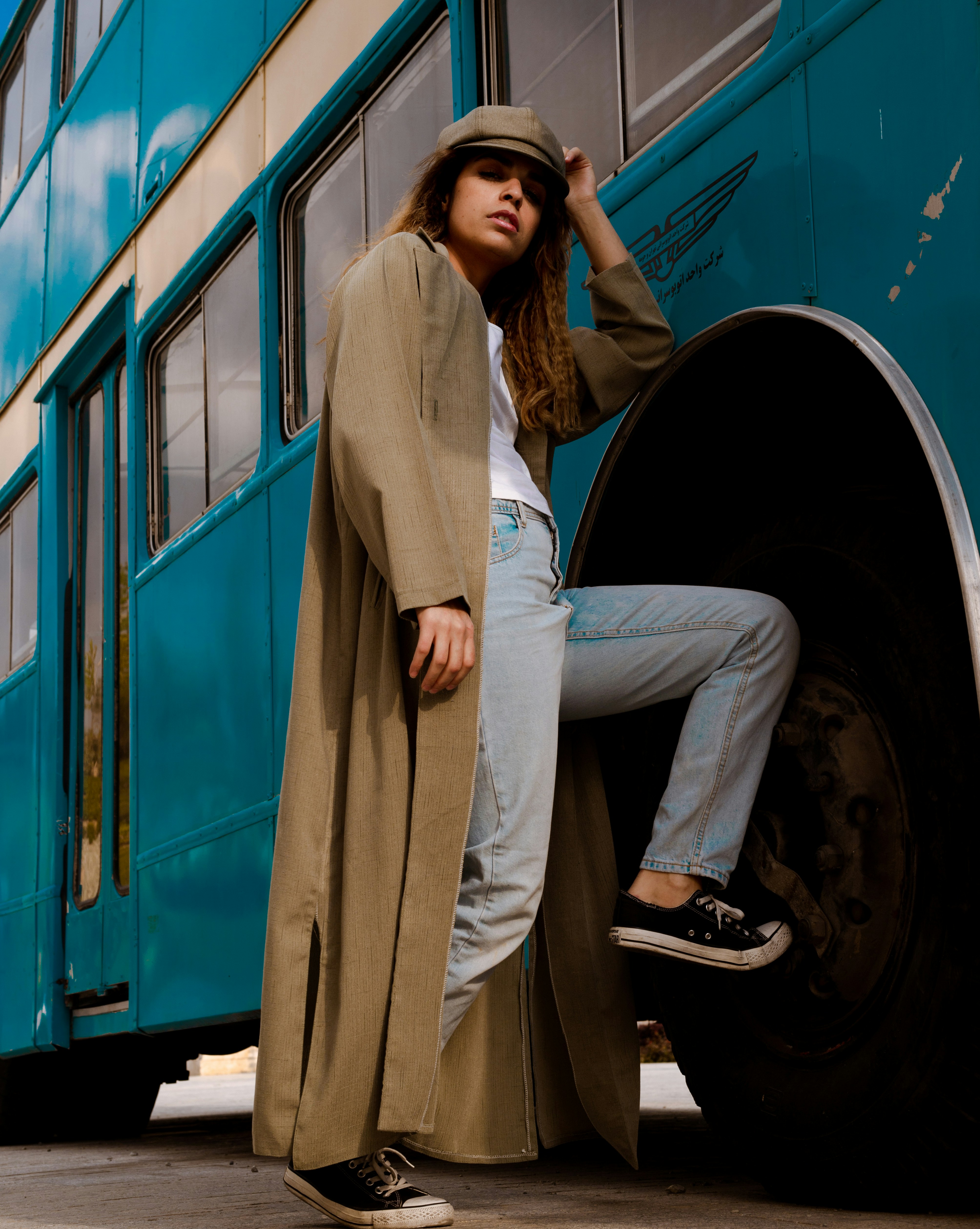 a woman leaning on the side of a blue bus