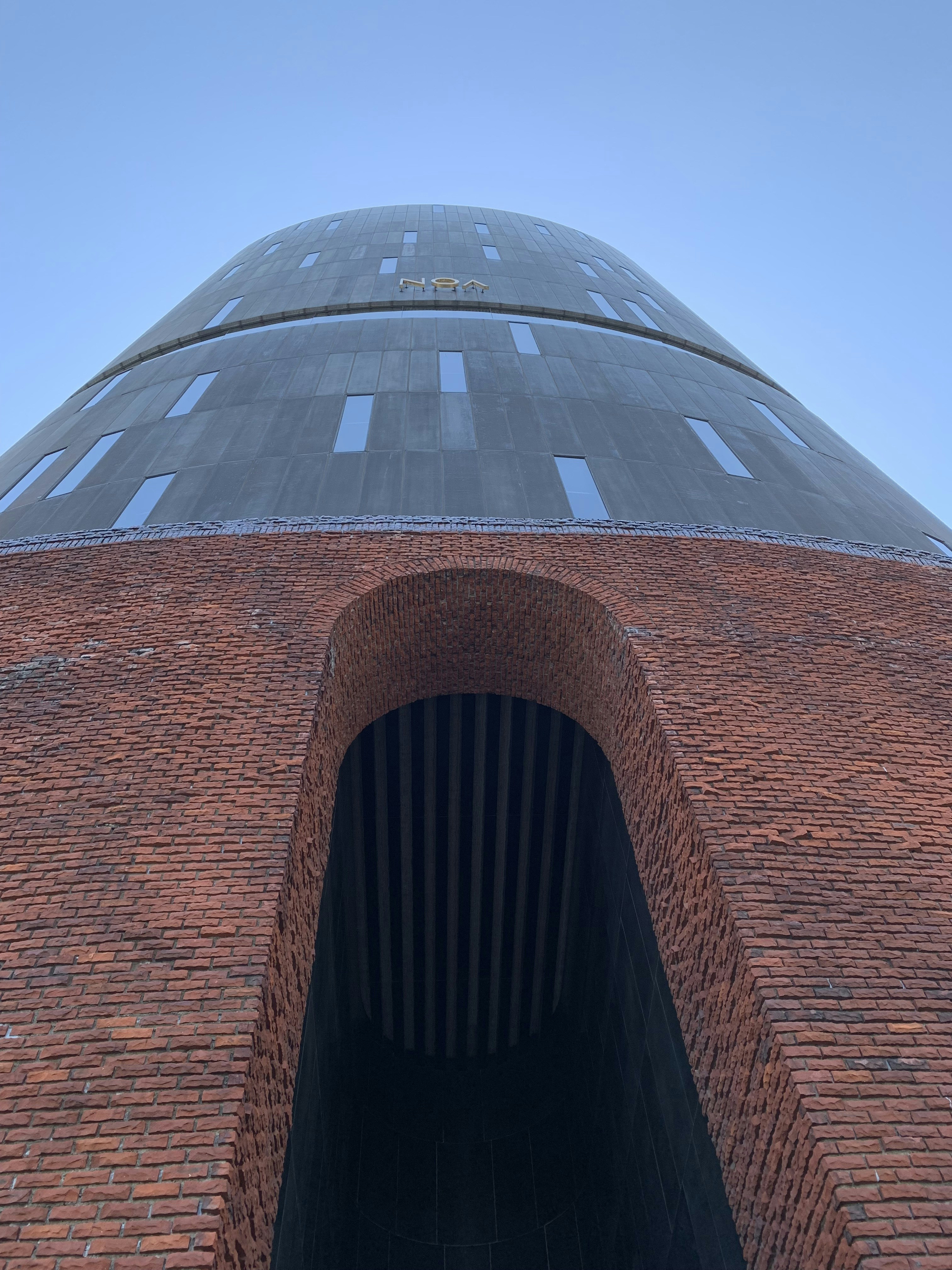 Archway Ascent: A Brick Portal Framing a Skyward Cylinder