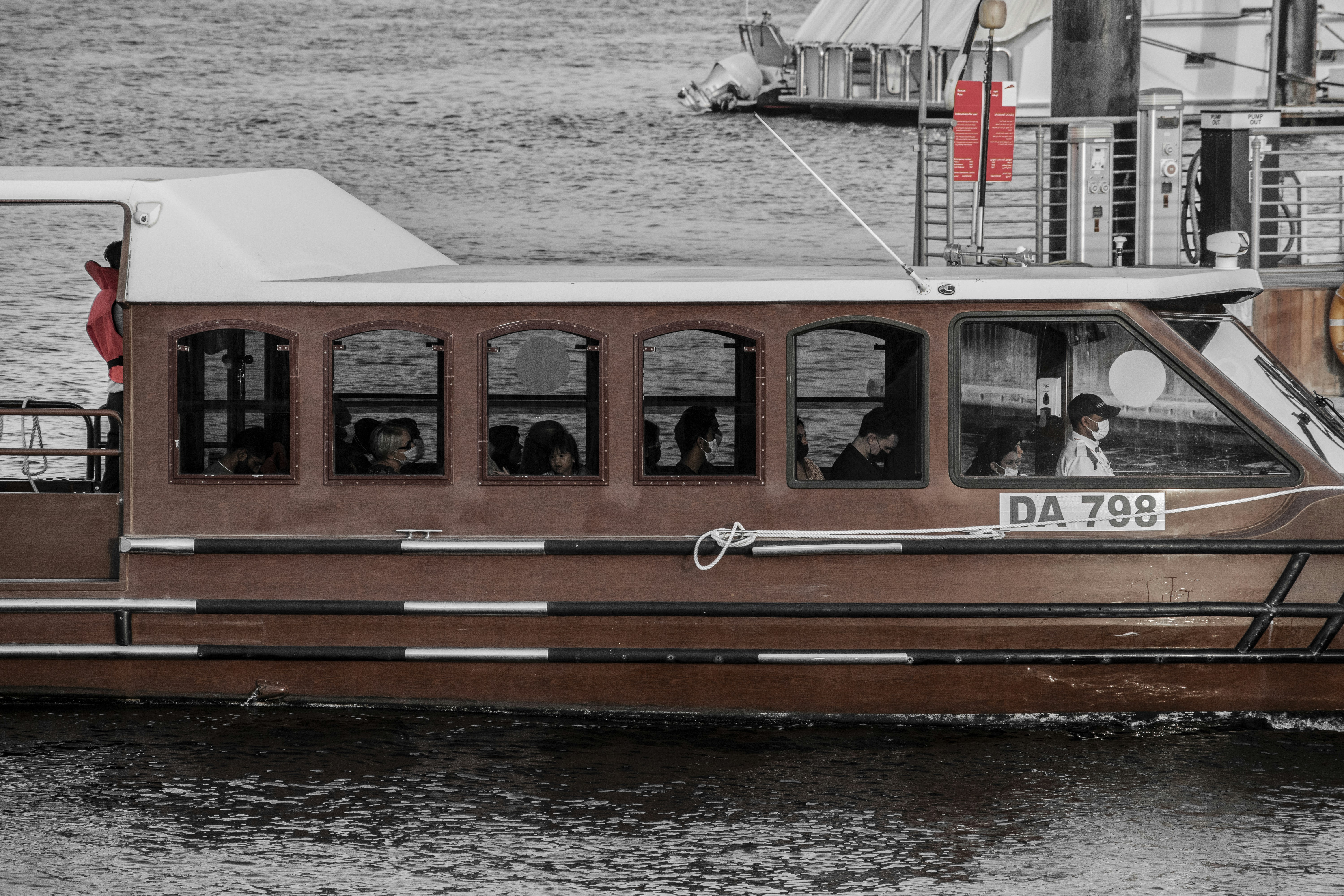 Passage Through Glass: Passengers in a Riverside Red Boat