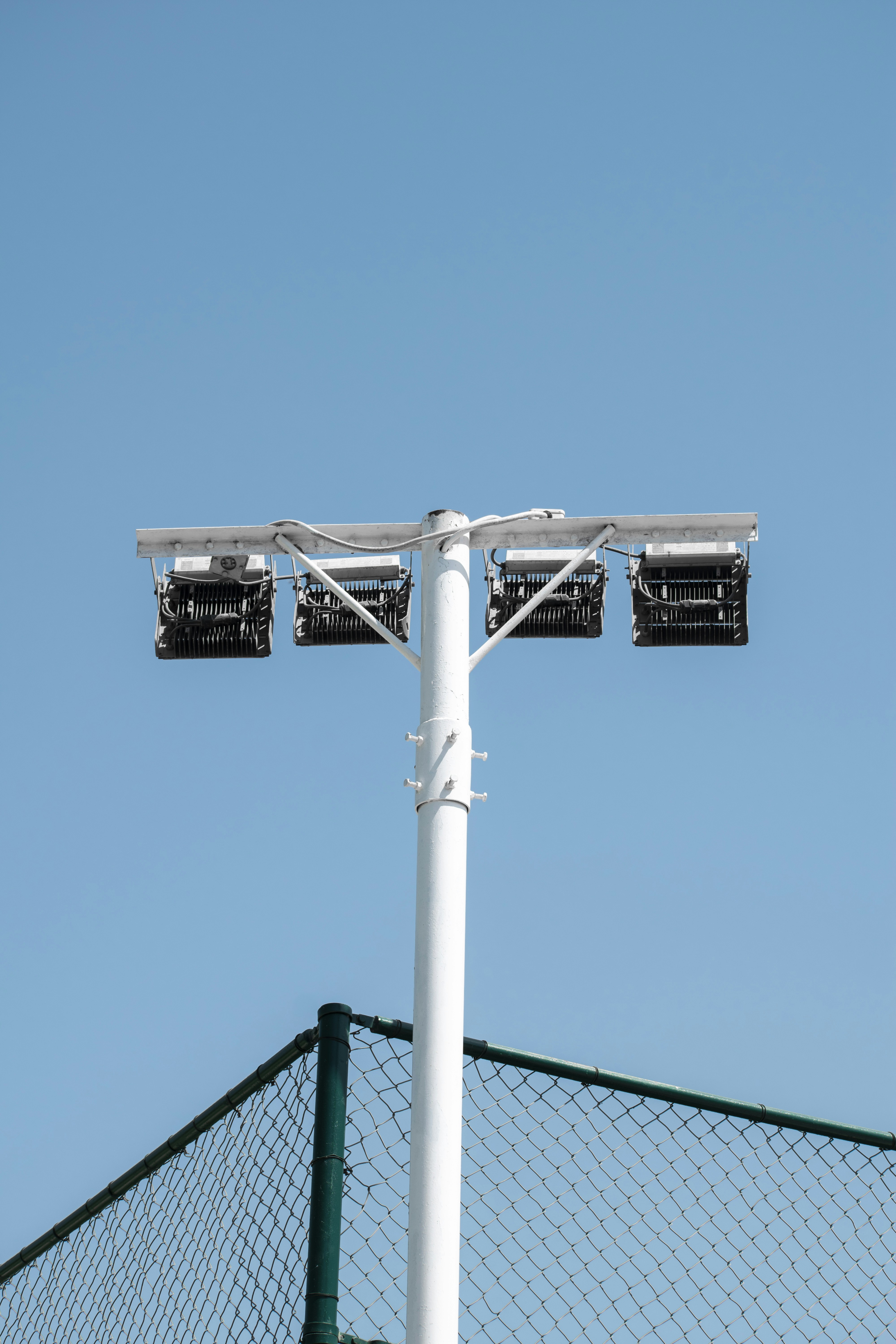 Four-Head Floodlight Tower Against a Pristine Blue Sky