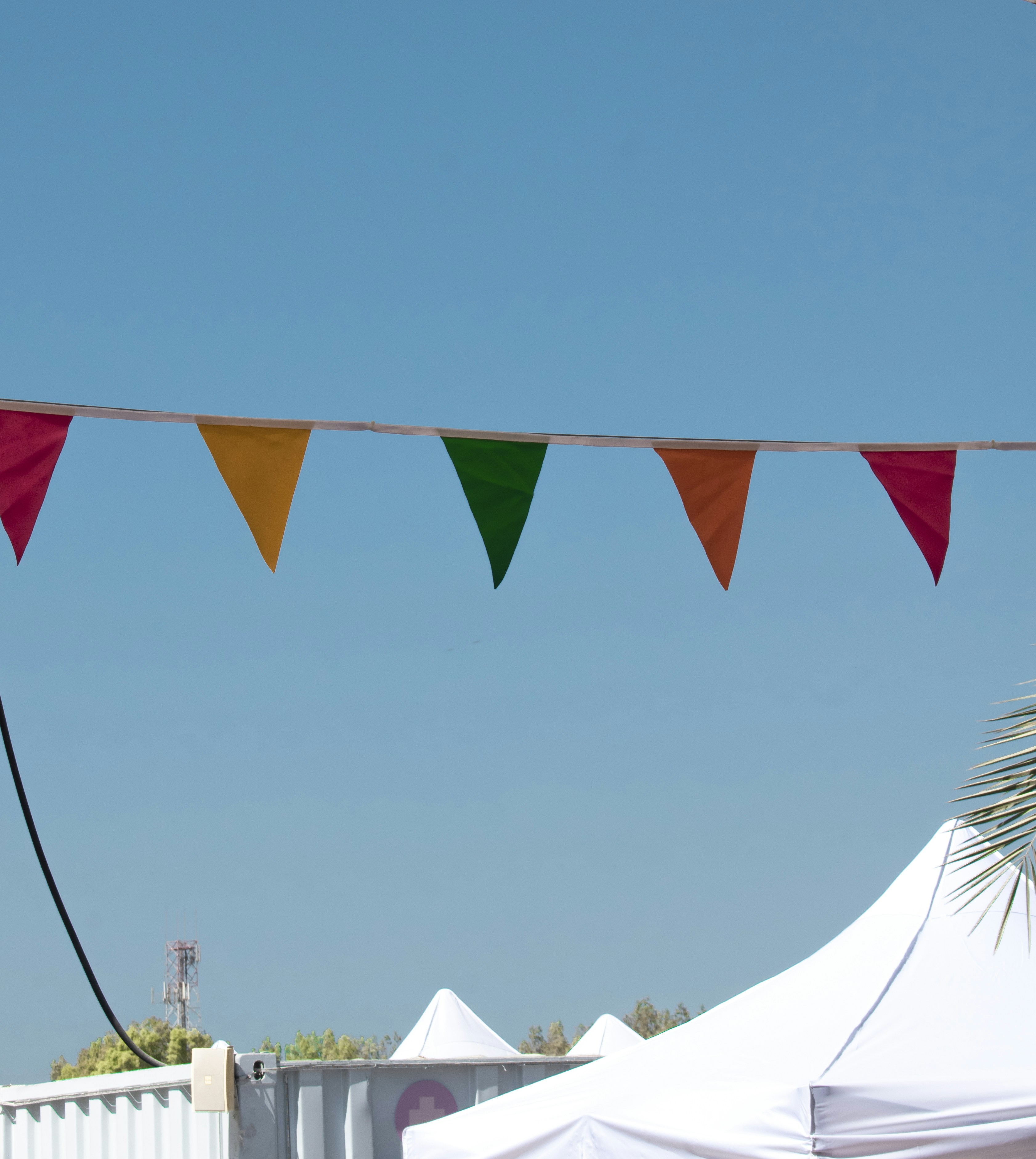 A group of tents with flags hanging from them photo – Free Summer Image ...