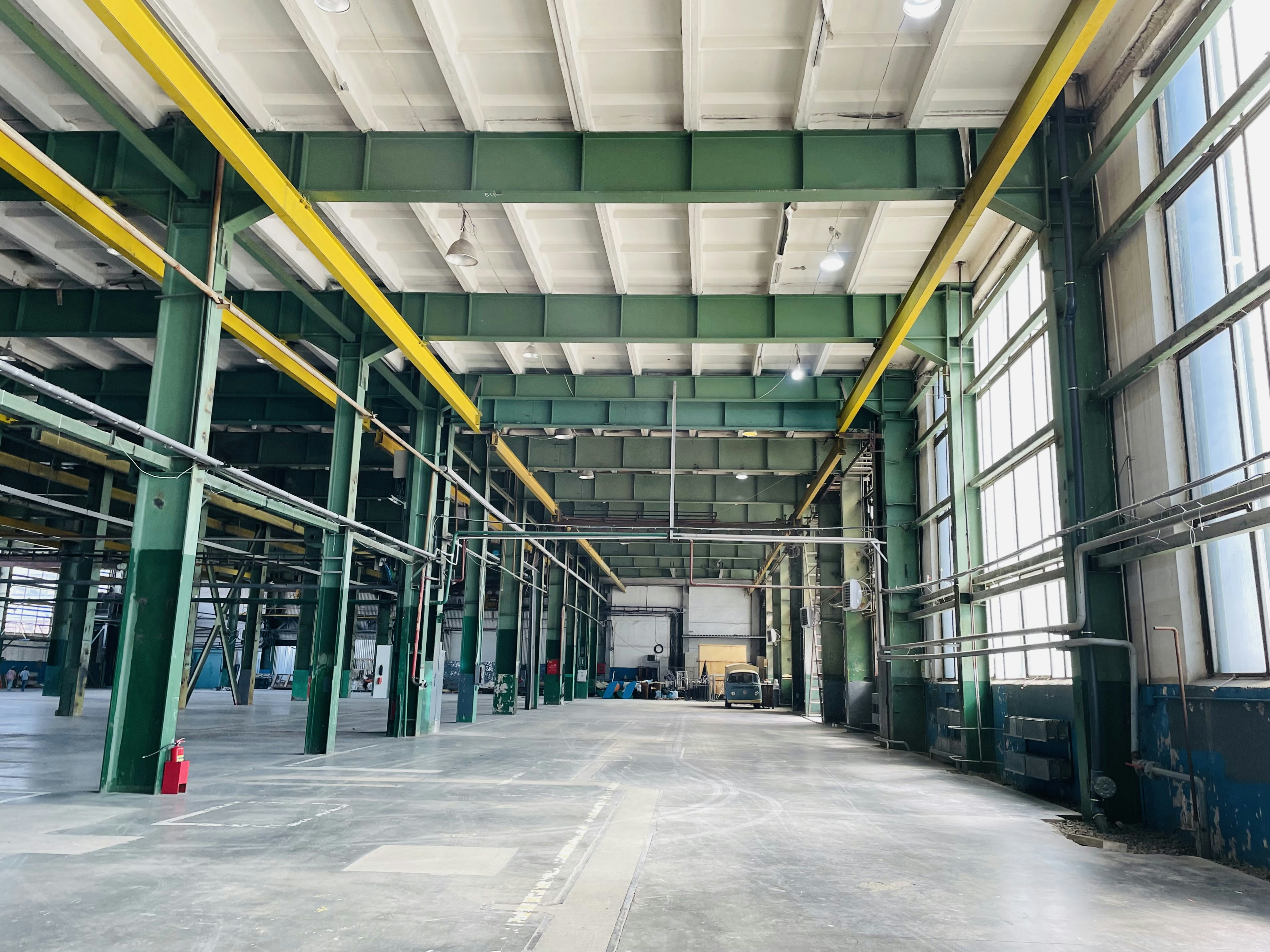 An empty warehouse with yellow and green pipes photo – Free ...