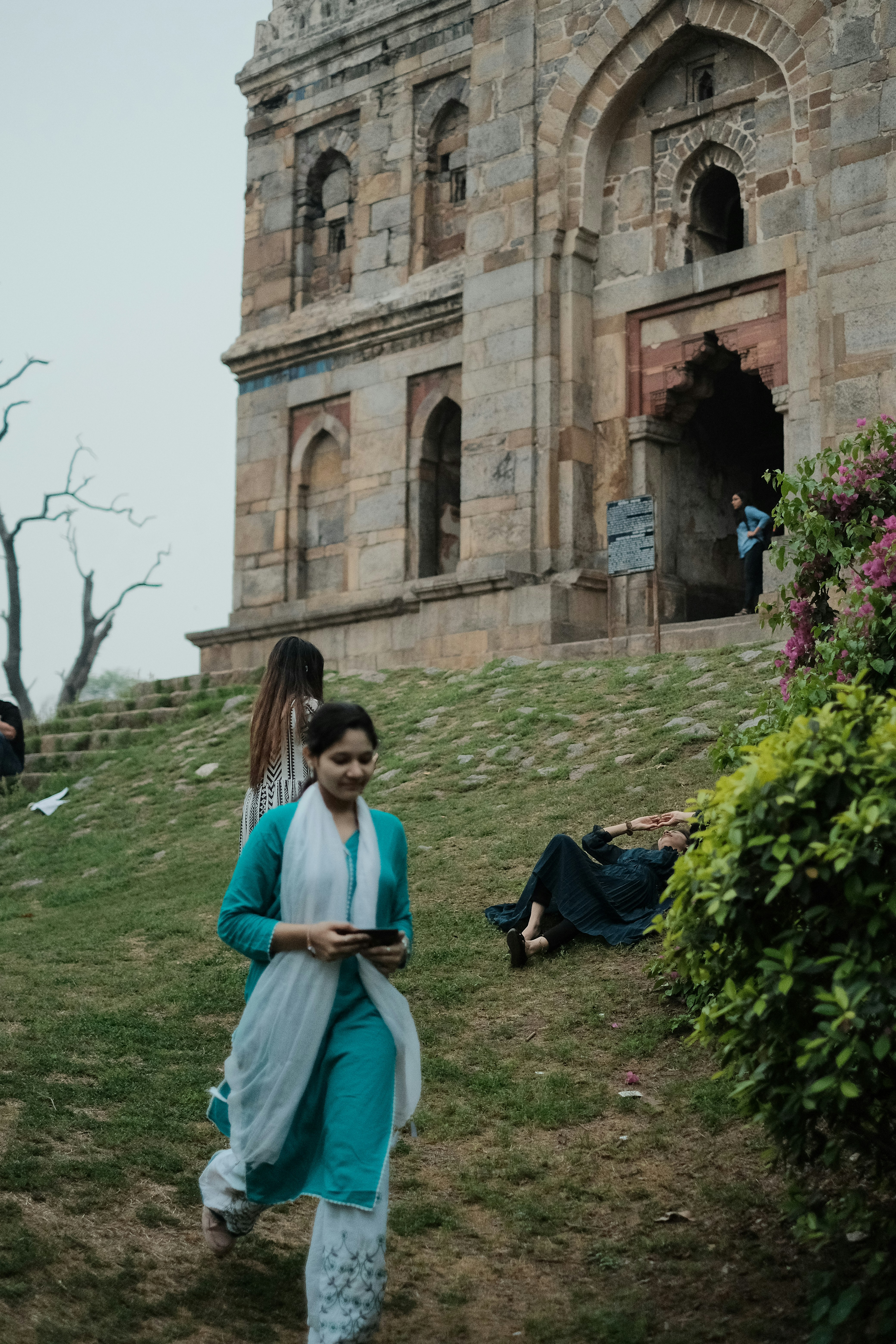 Turquoise-clad wanderer at the base of an ancient stone temple