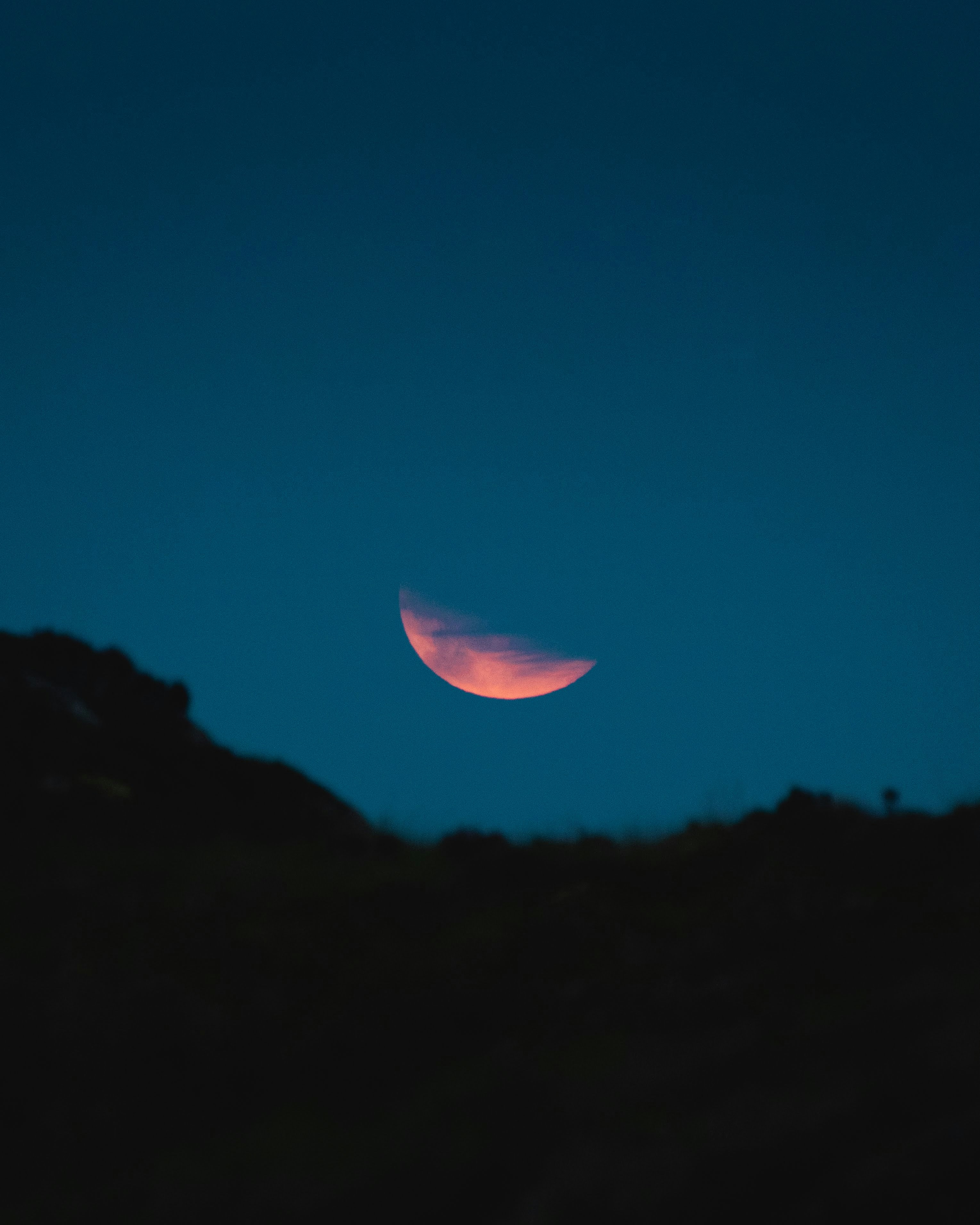 A half moon is seen in the sky above a hill photo – Free Moon Image on ...