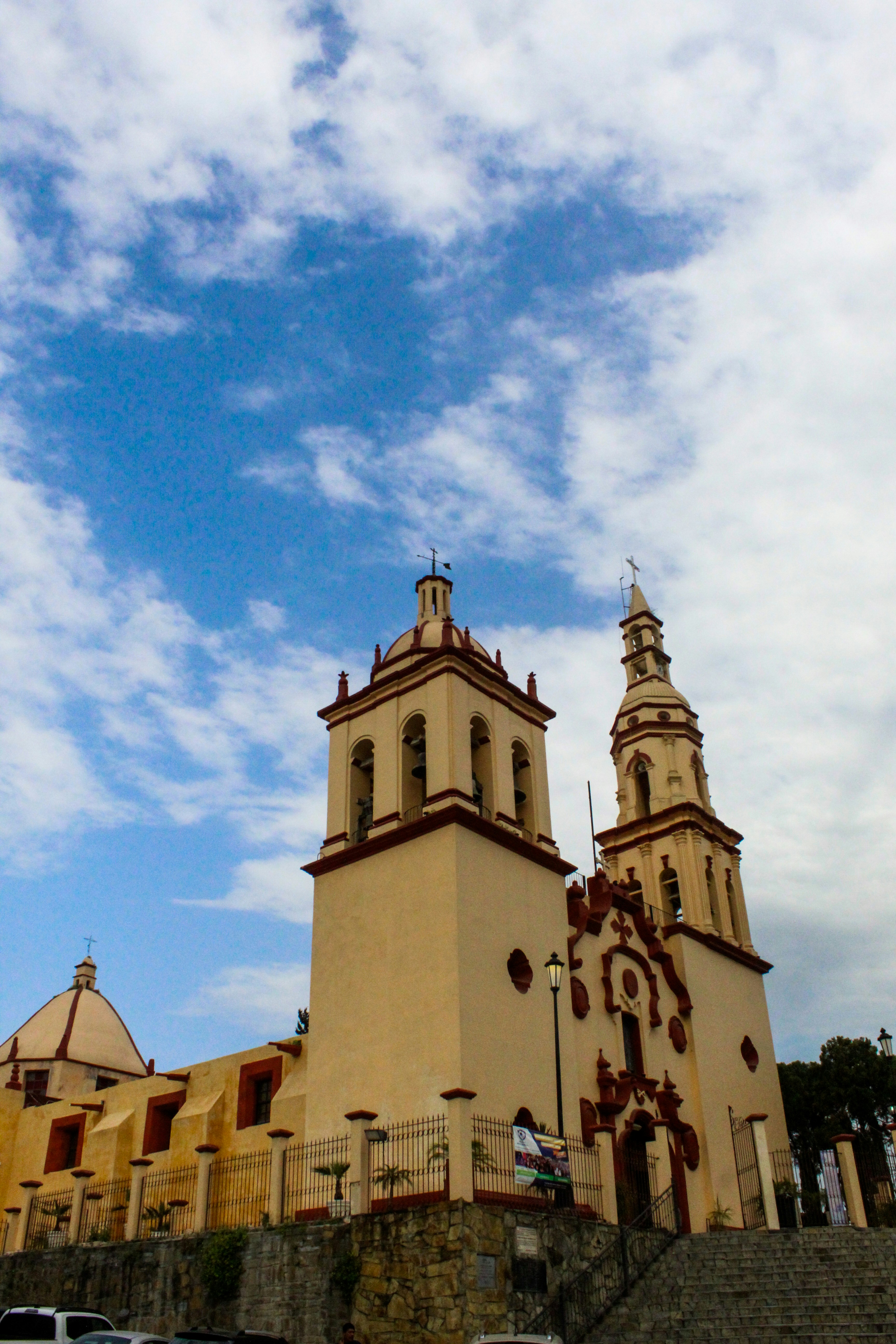 Majestic church towers rise against a backdrop of blue sky and scattered clouds.