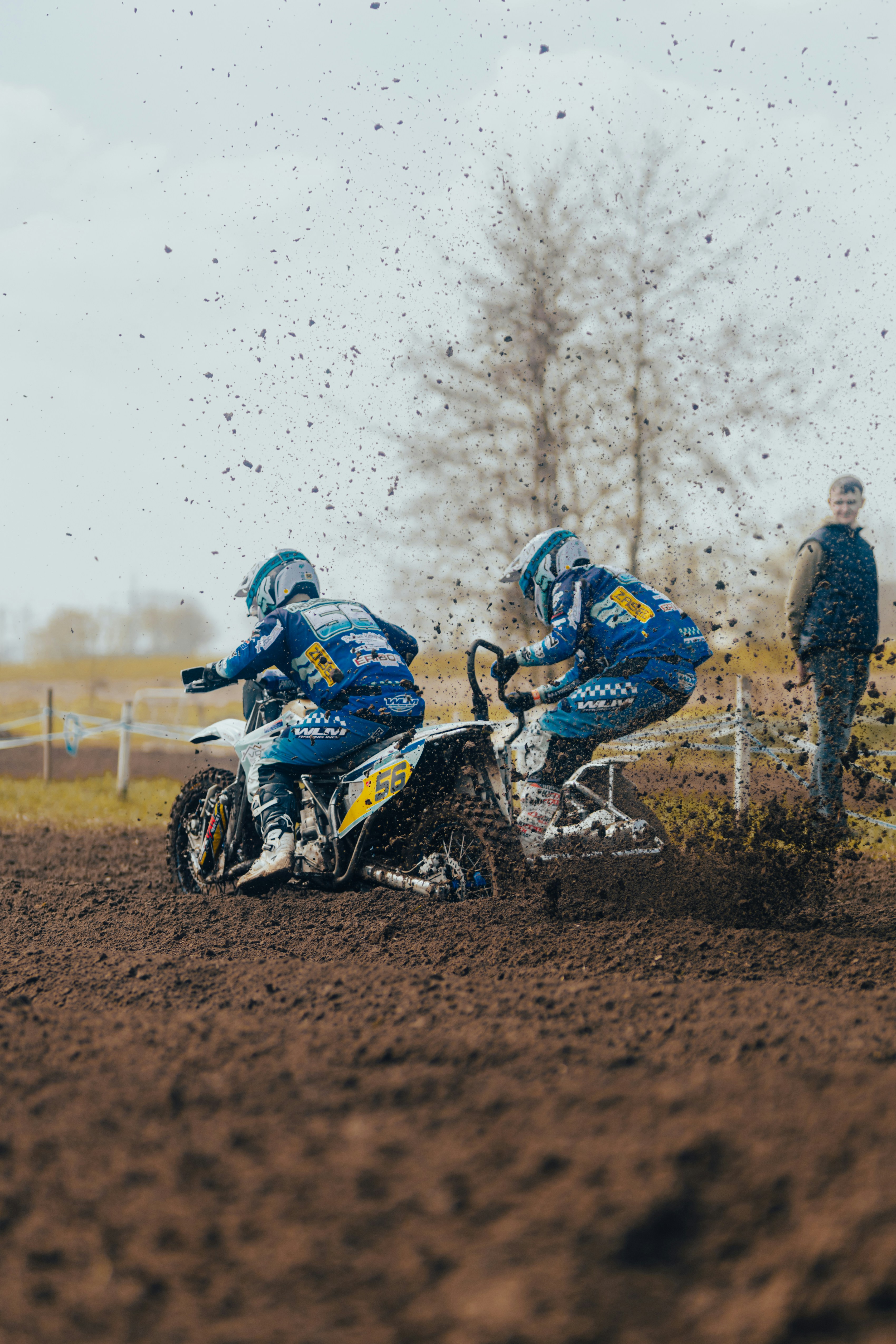 Dirt Track Duel: Motocross Duo carving through spray and dust